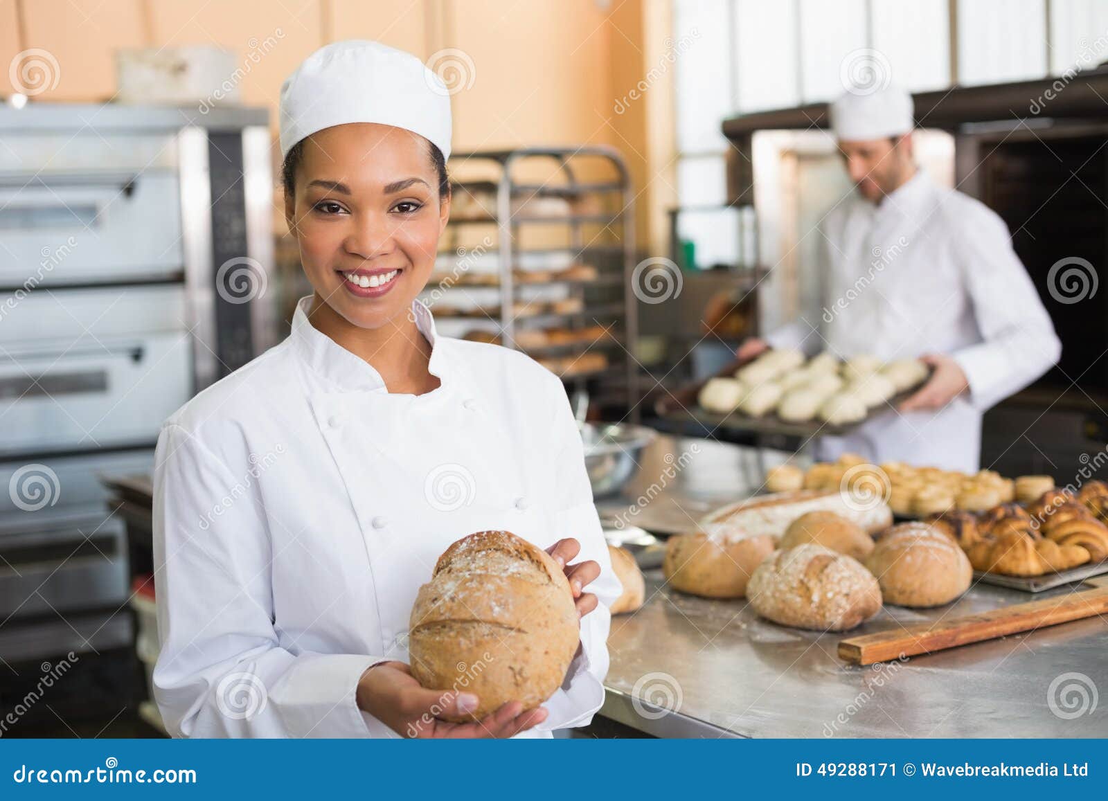 Pretty Baker Smiling at Camera with Loaf Stock Image - Image of indoors ...