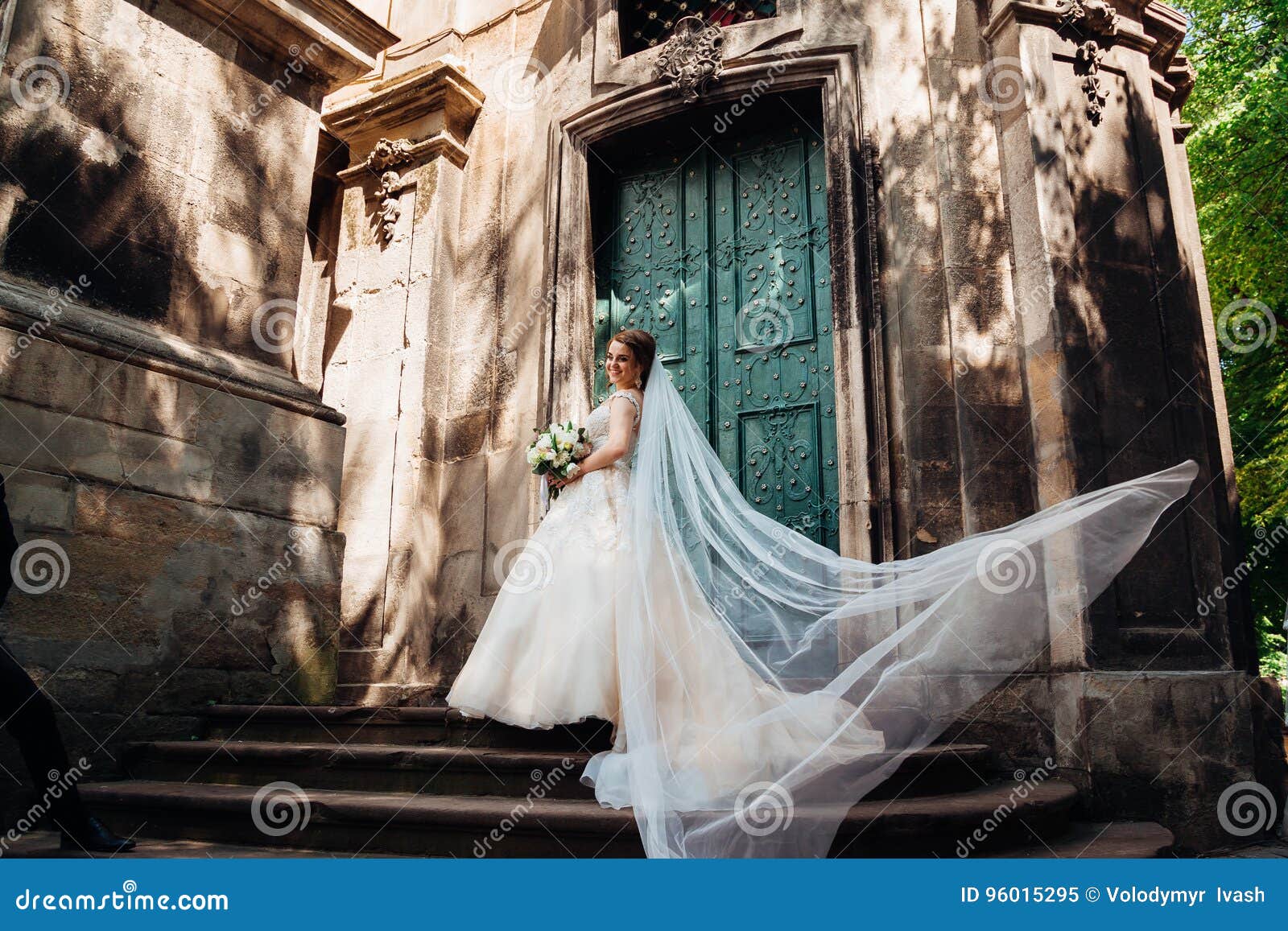 Pretty Bride Looks Over Her Shoulder while Wind Blows Her Veil Stock ...