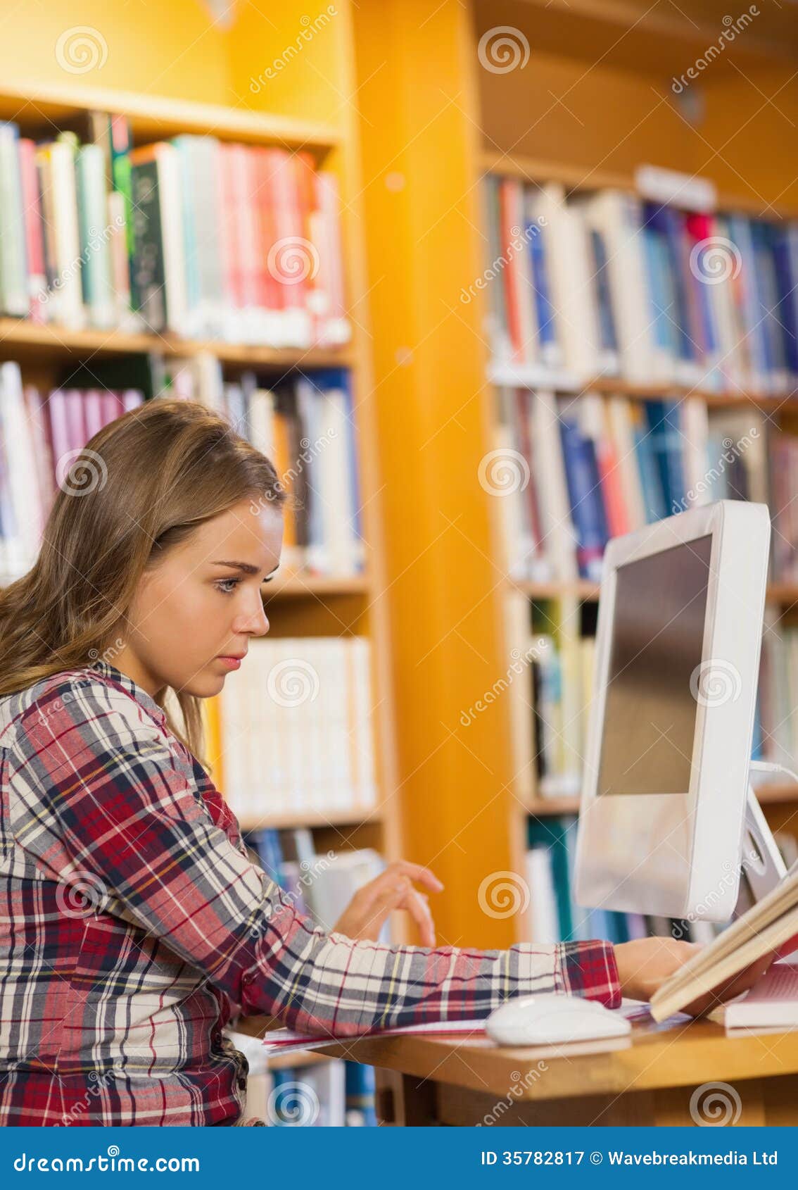 Pretty Concentrating Student Reading Book Using Computer Stock Image ...
