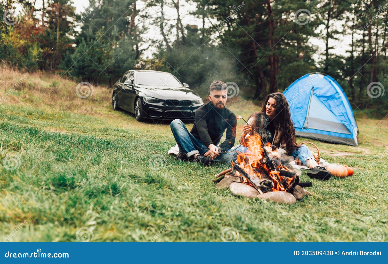Pretty Couple Near the Campfire Makes Roasted Marshmallows. Stock Photo ...