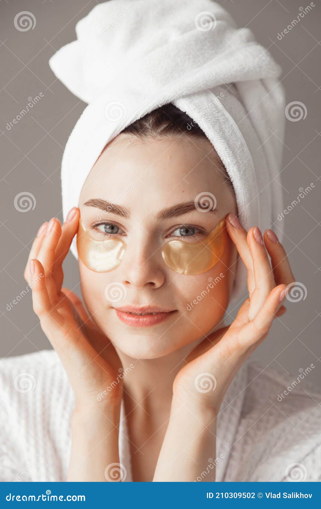 Pretty European Girl Applying Golden Collagen Patches Under Her Eyes