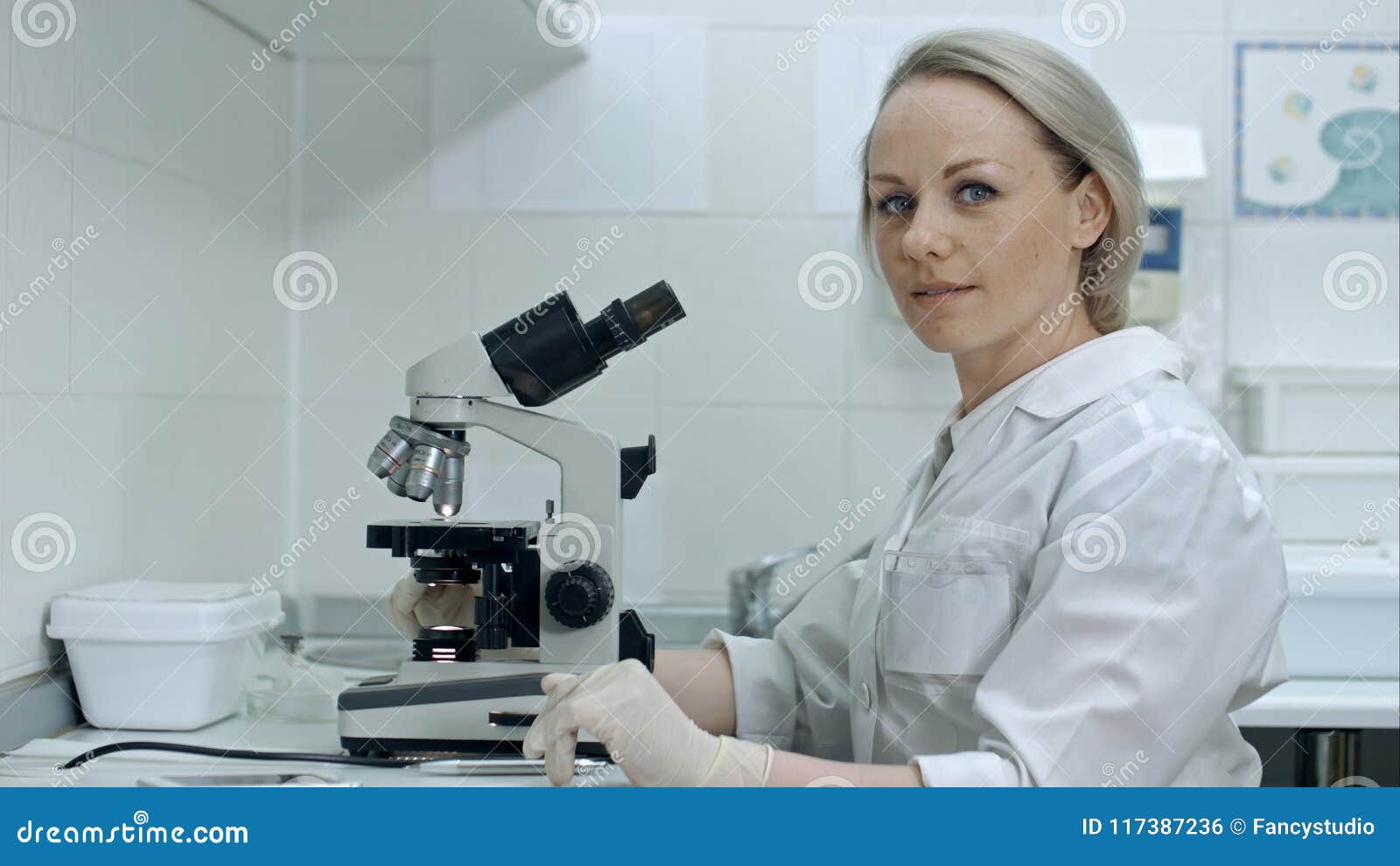 Pretty Female with Microscope Looking at Camera in Laboratory Stock ...