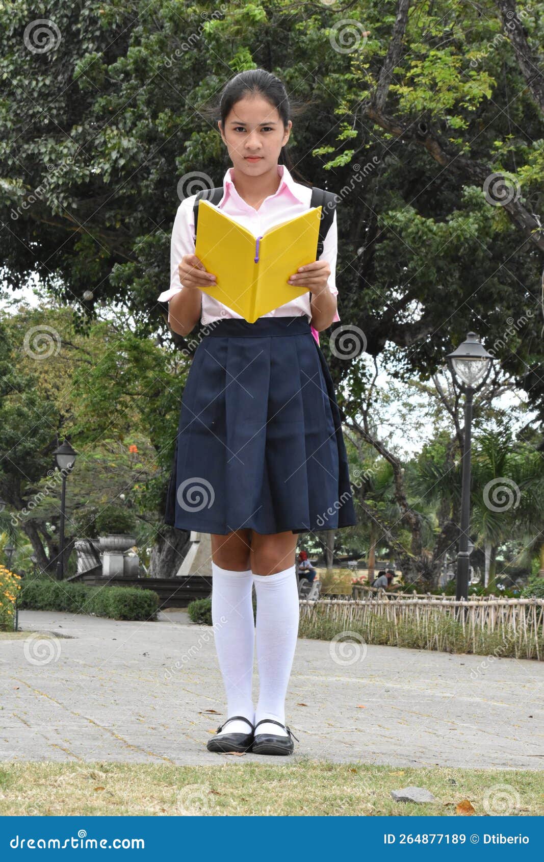 Pretty Female Student Reading Wearing Uniform with Books Standing Stock ...