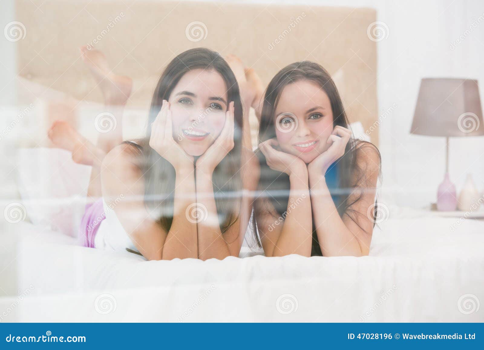 Pretty Friends Smiling at Camera on Bed Stock Photo - Image of people ...