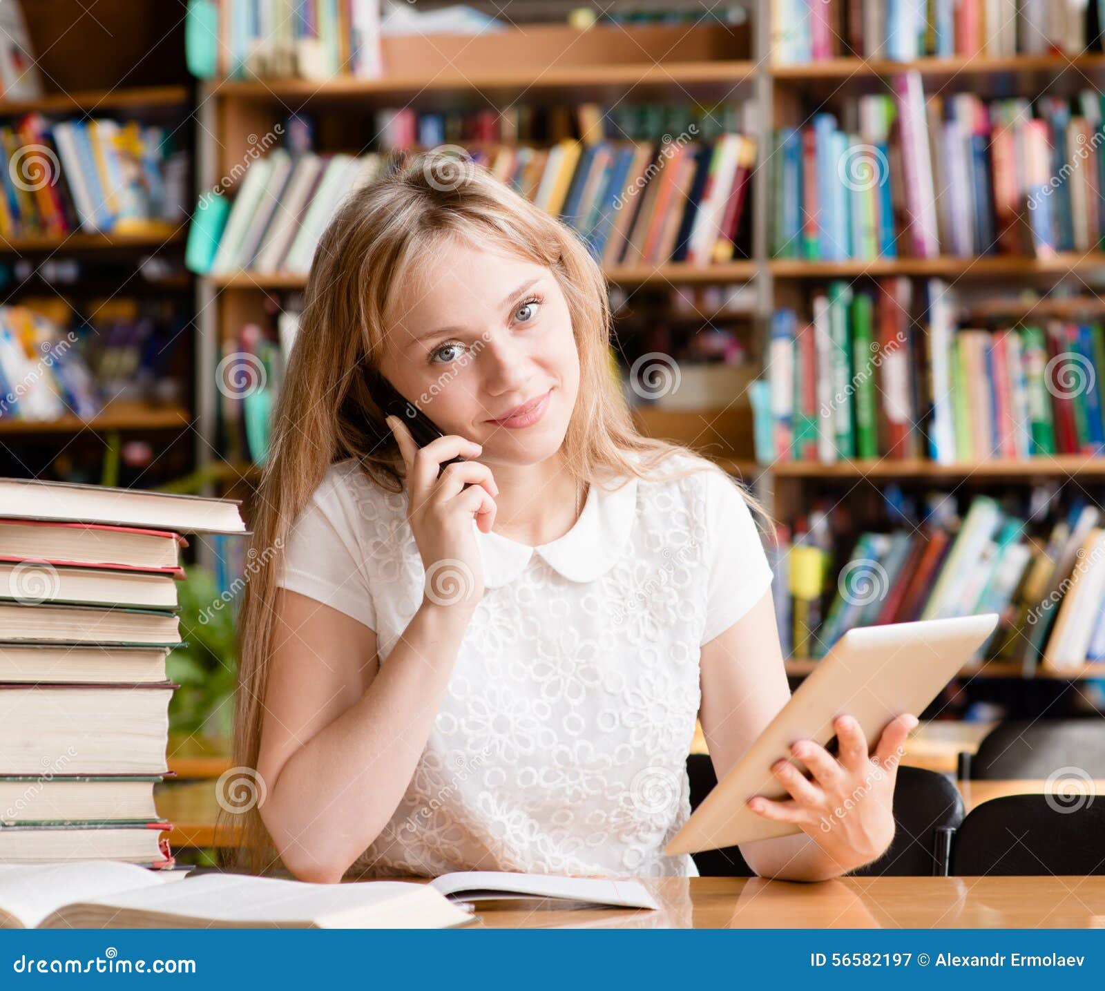 Pretty Girl in Library Using Tablet Computer and Talking on the Phone ...
