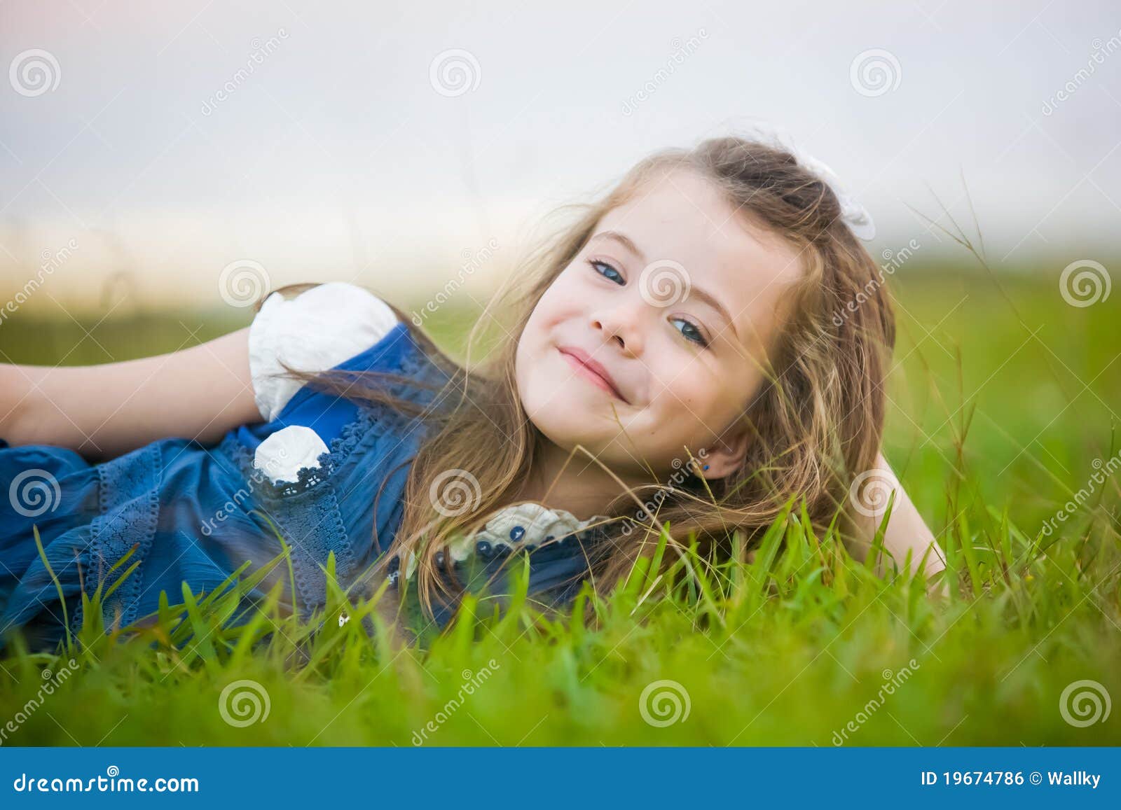 A Pretty Girl Relaxing on the Grass Stock Photo - Image of blue, cheeky ...