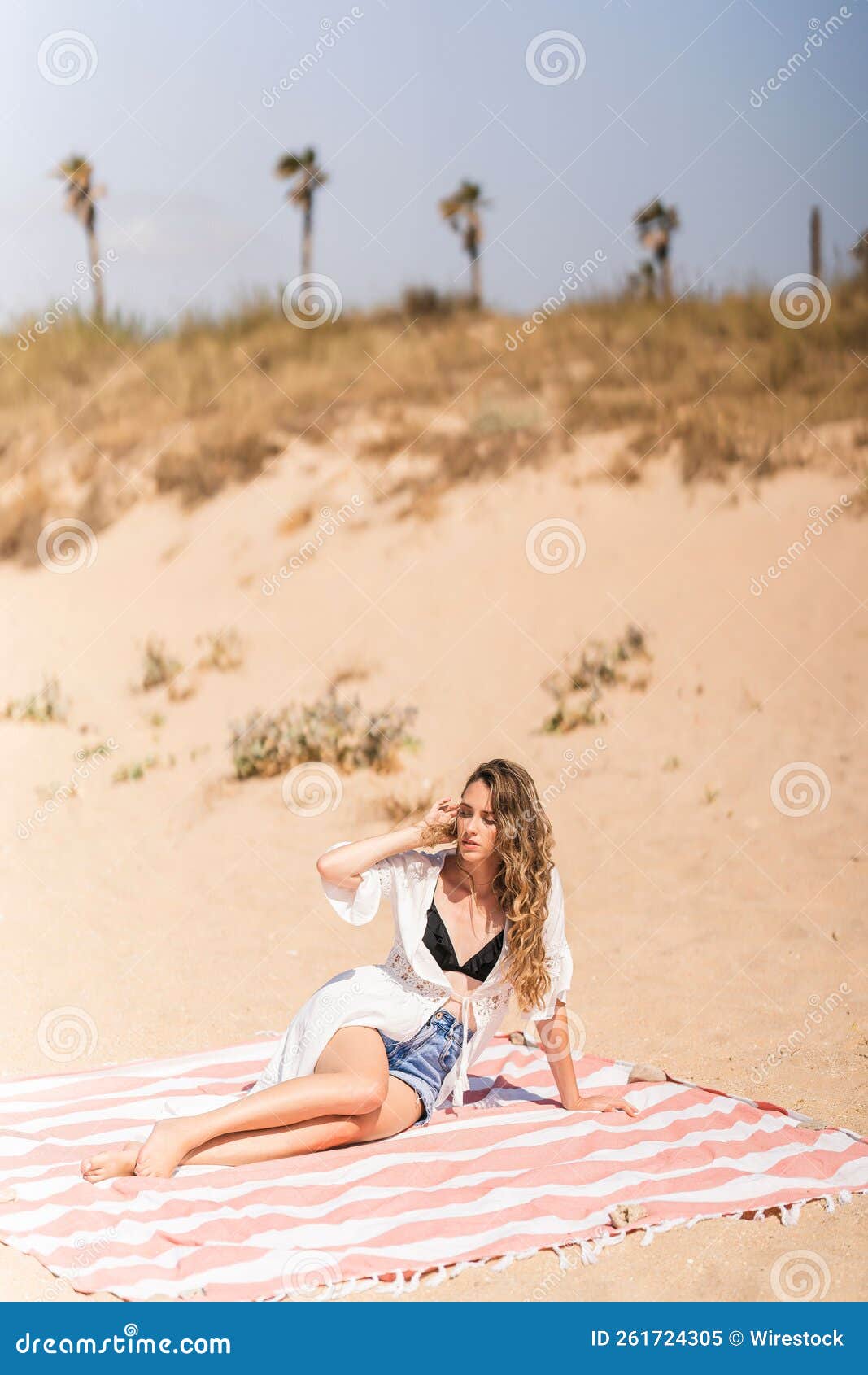 A Pretty Lady Lying Down on a Towel on a Sandy Beach Stock Image ...