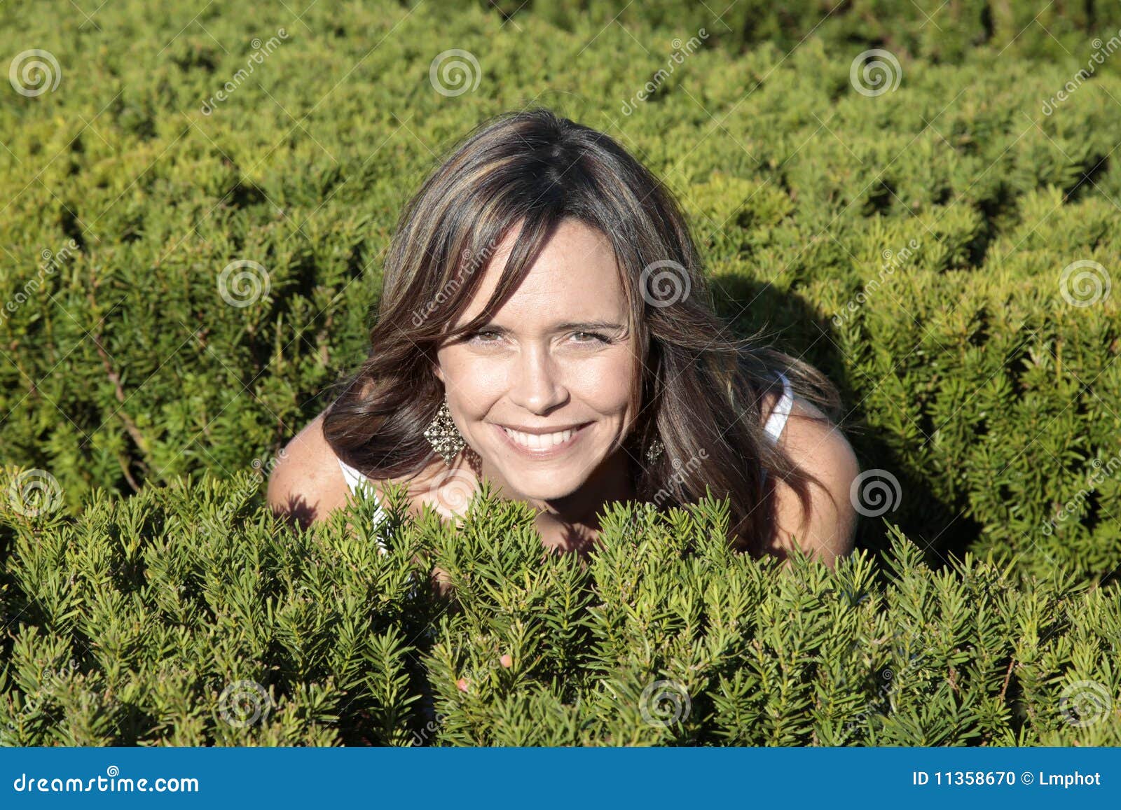 Pretty Mother Crouching in Bushes Stock Photo - Image of carefree ...