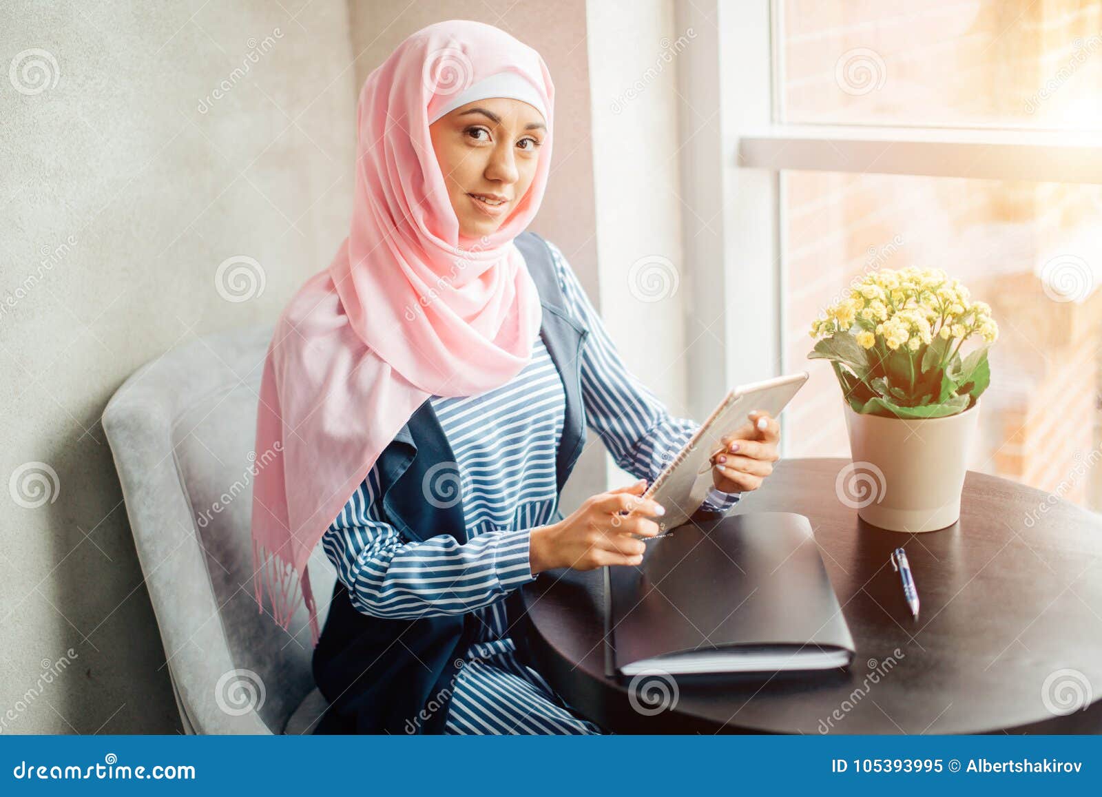 Female Muslim College Student Using Tablet Computer in Cafe Stock Image ...