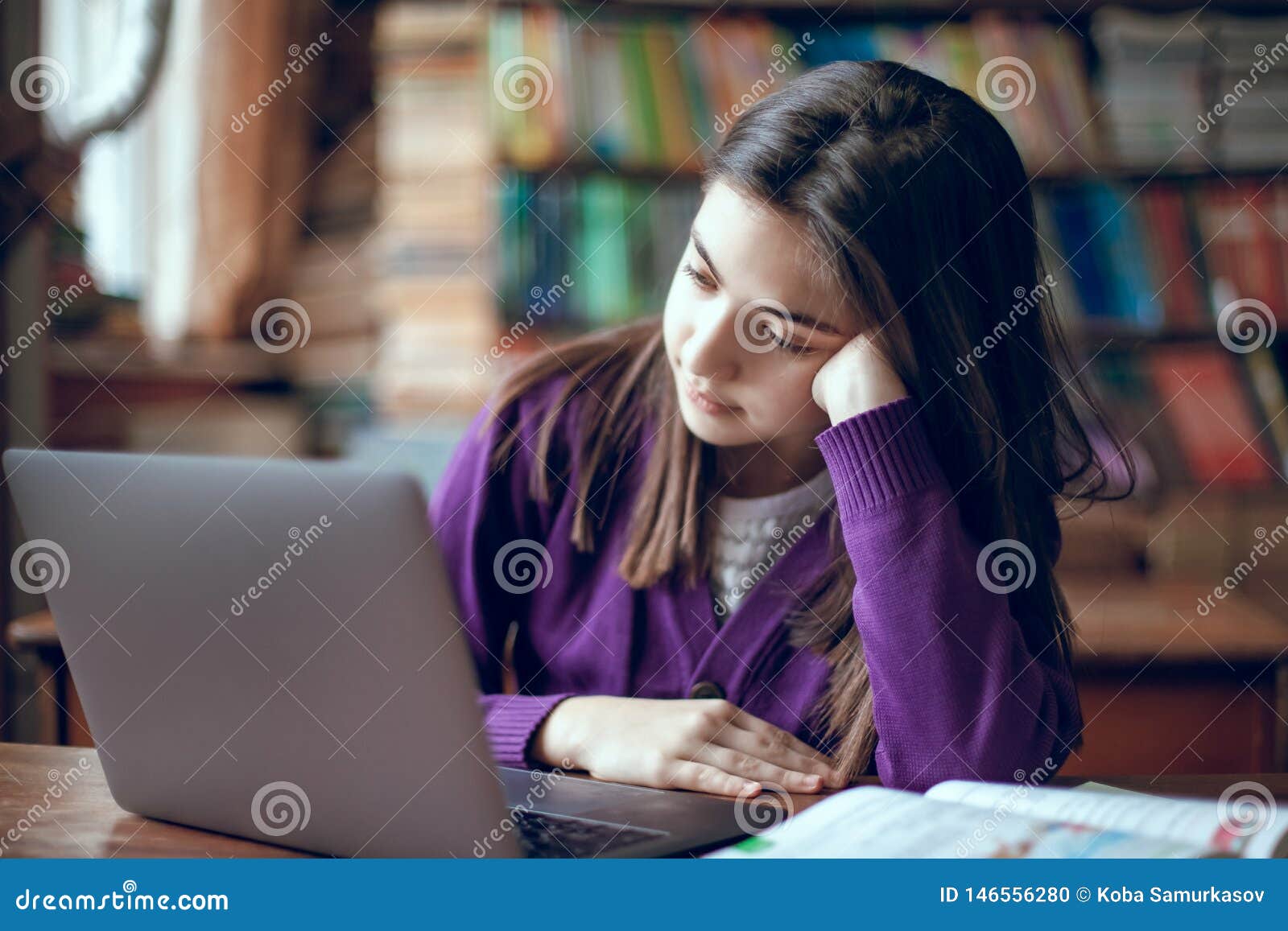 Pretty School Girl Studying in the School Library Using Laptop Stock ...