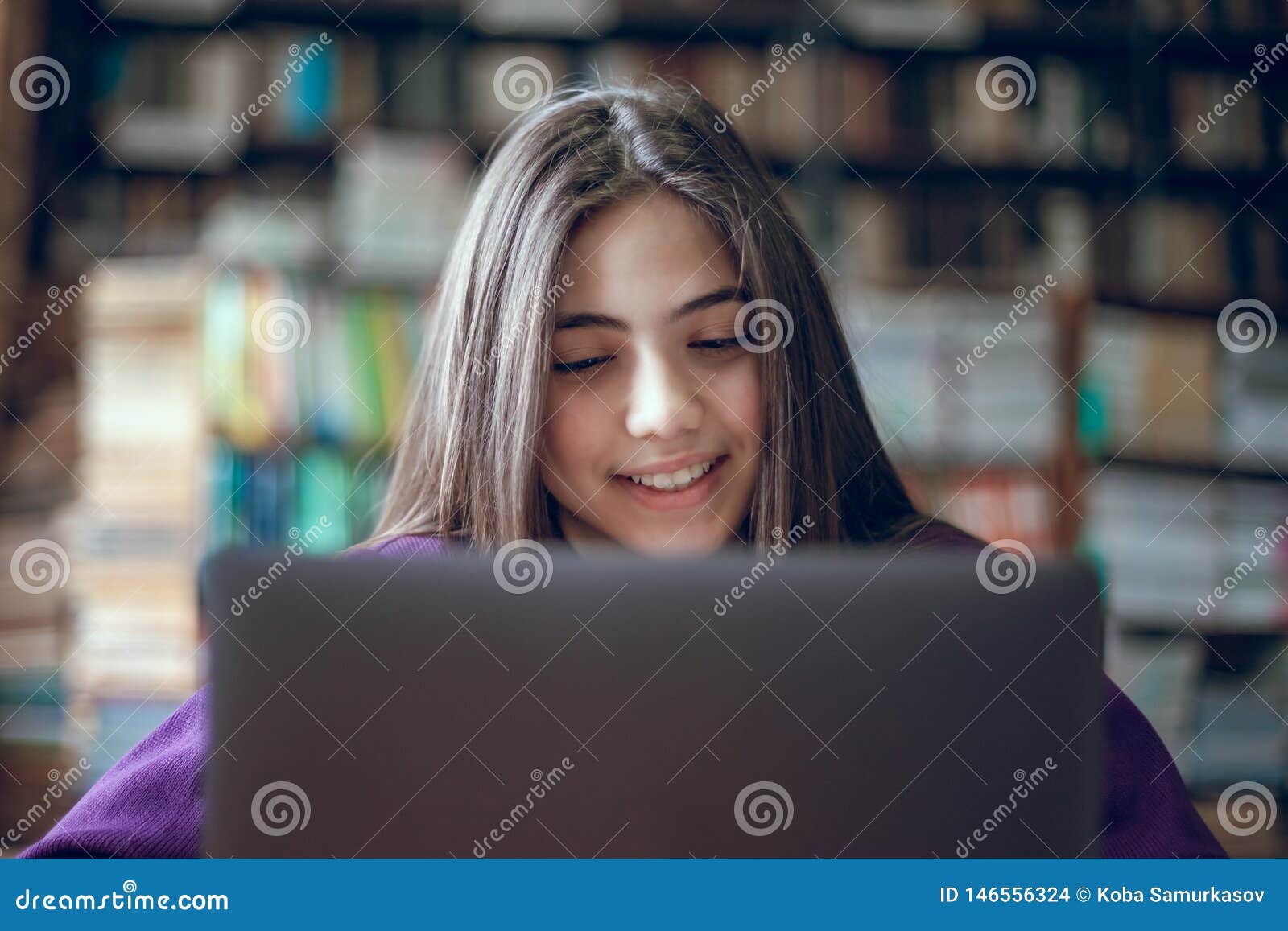 Pretty School Girl Studying in the School Library Using Laptop Stock ...