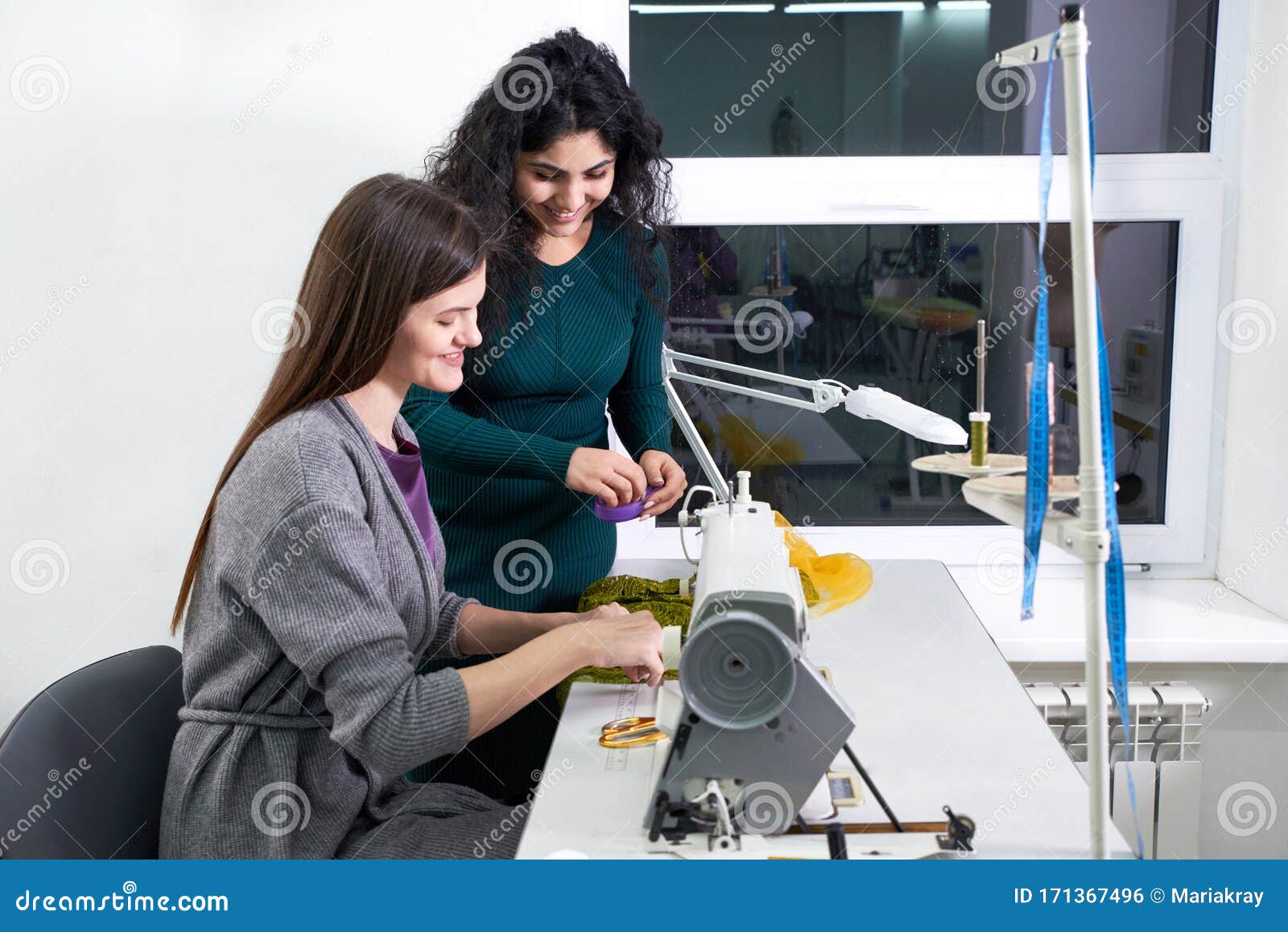 Pretty Seamstress Teaching Girl Working with Sewing Machine at Sewing ...