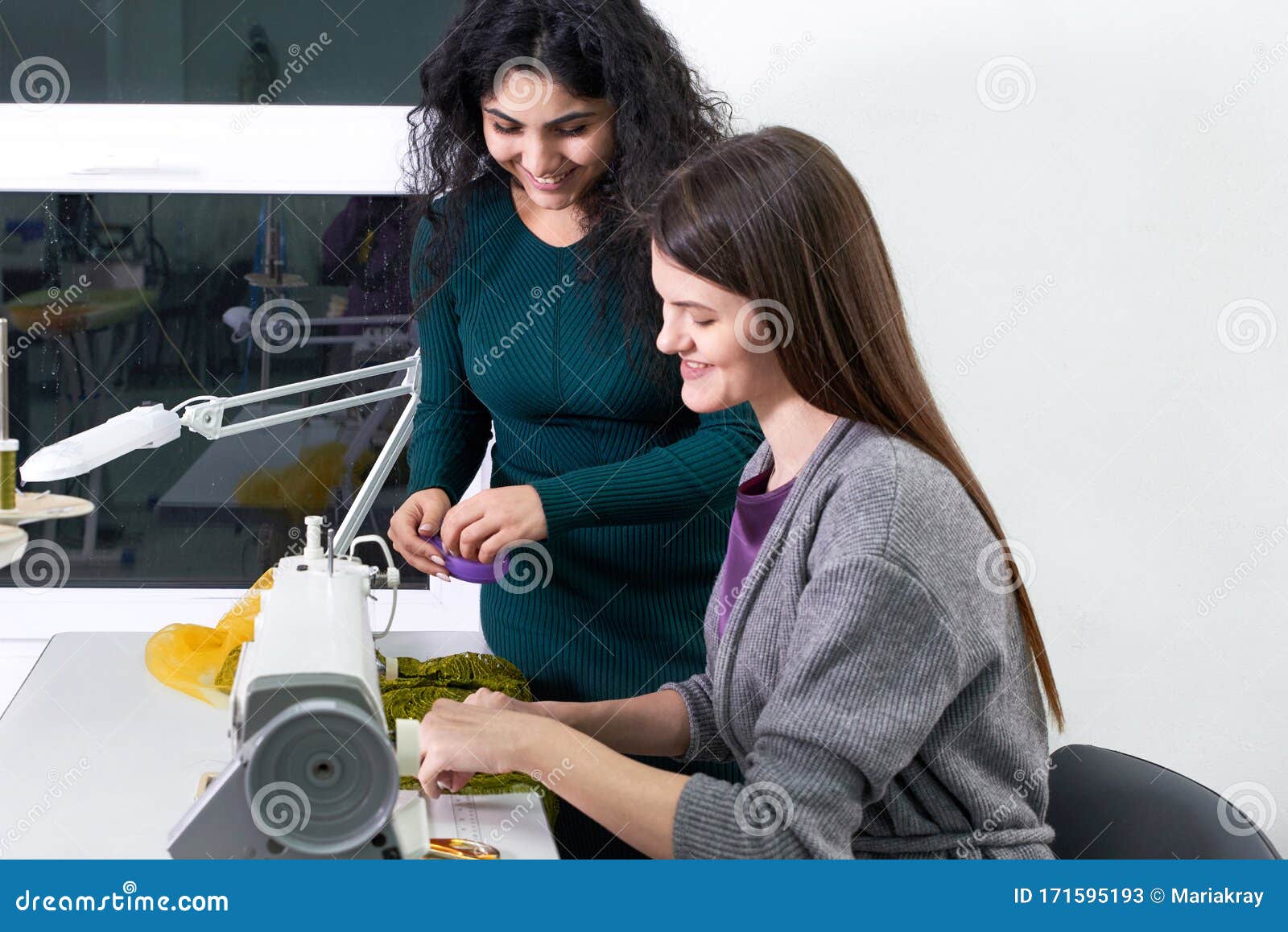 Pretty Seamstress Teaching Girl Working with Sewing Machine at Sewing ...