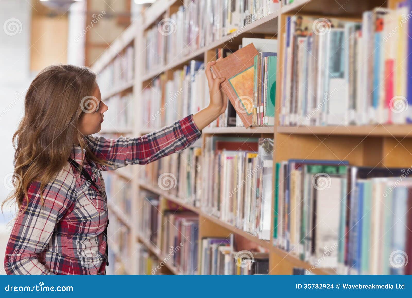 Pretty Student Placing Book in Shelf Stock Photo - Image of research ...