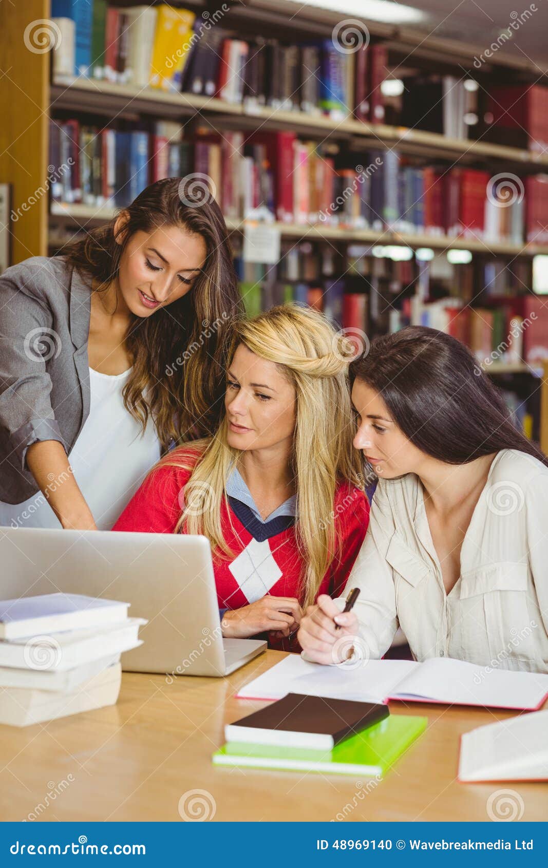 Pretty Student Showing Her Classmates Something on Laptop Stock Photo ...