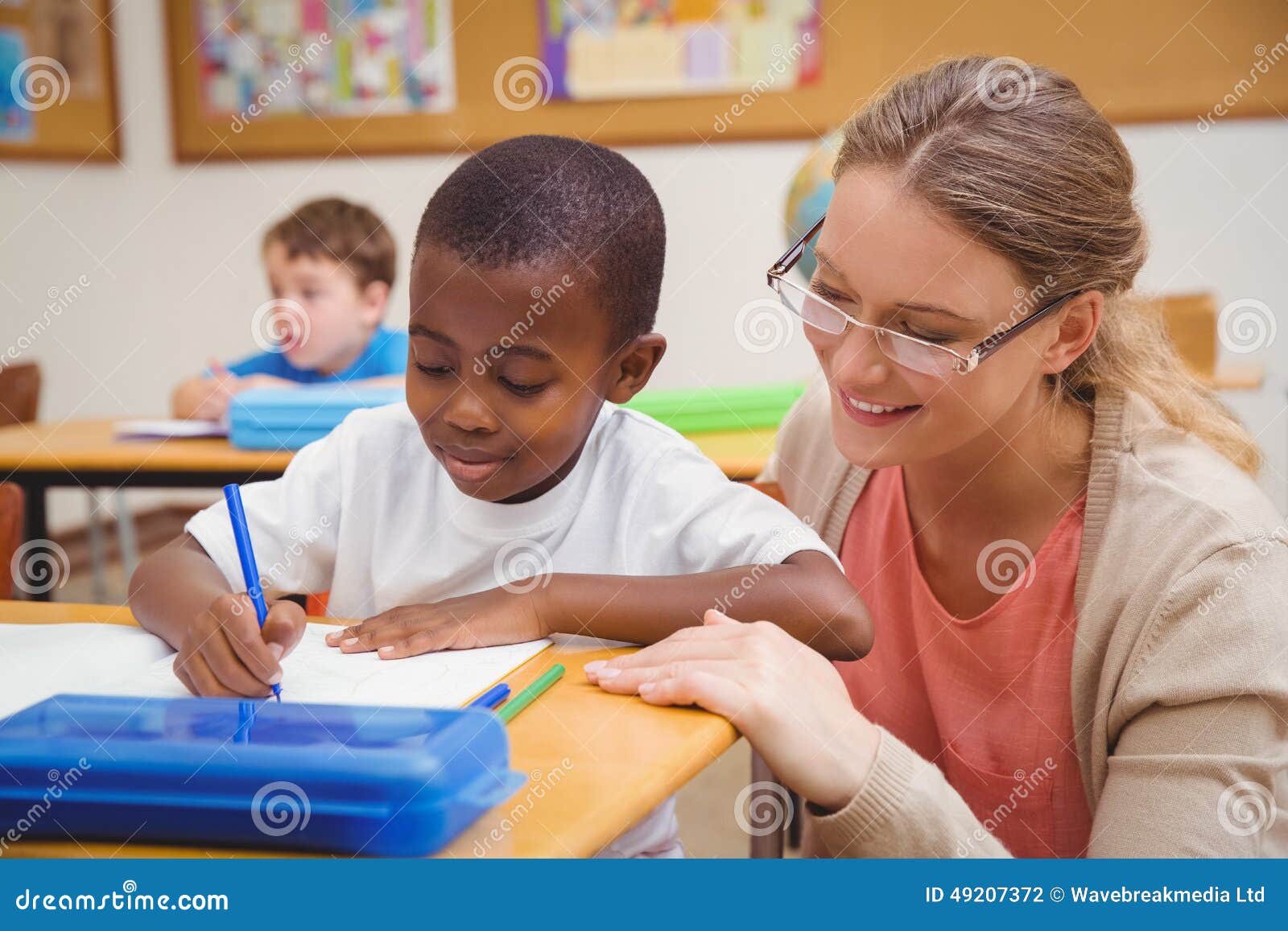 Pretty Teacher Helping Pupil in Classroom Stock Photo - Image of ...