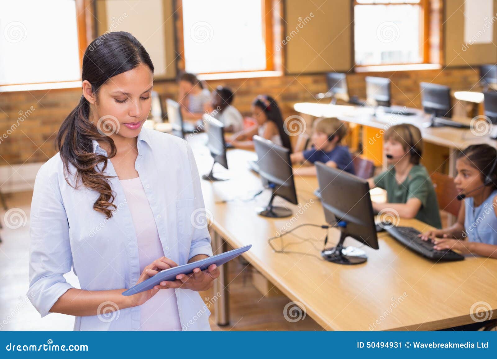 Pretty Teacher Using Tablet Computer in Computer Class Stock Image ...