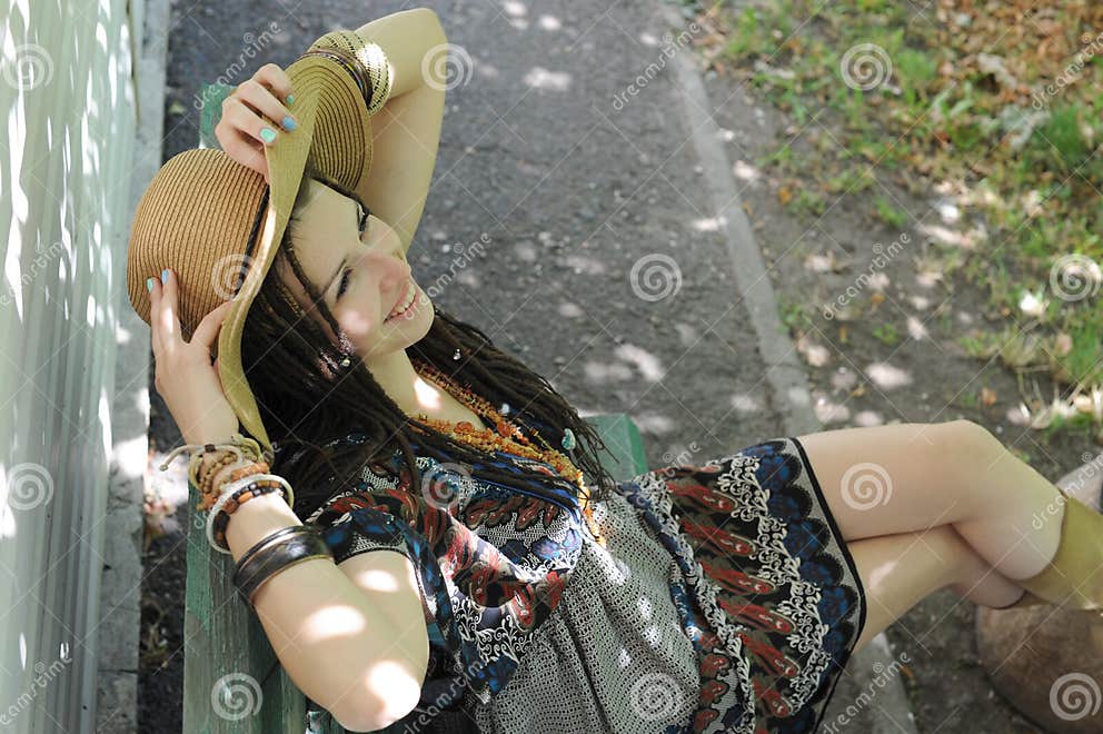 Pretty Woman With Dreadlocks Dressed In Boho Style Dress And Hat Stock