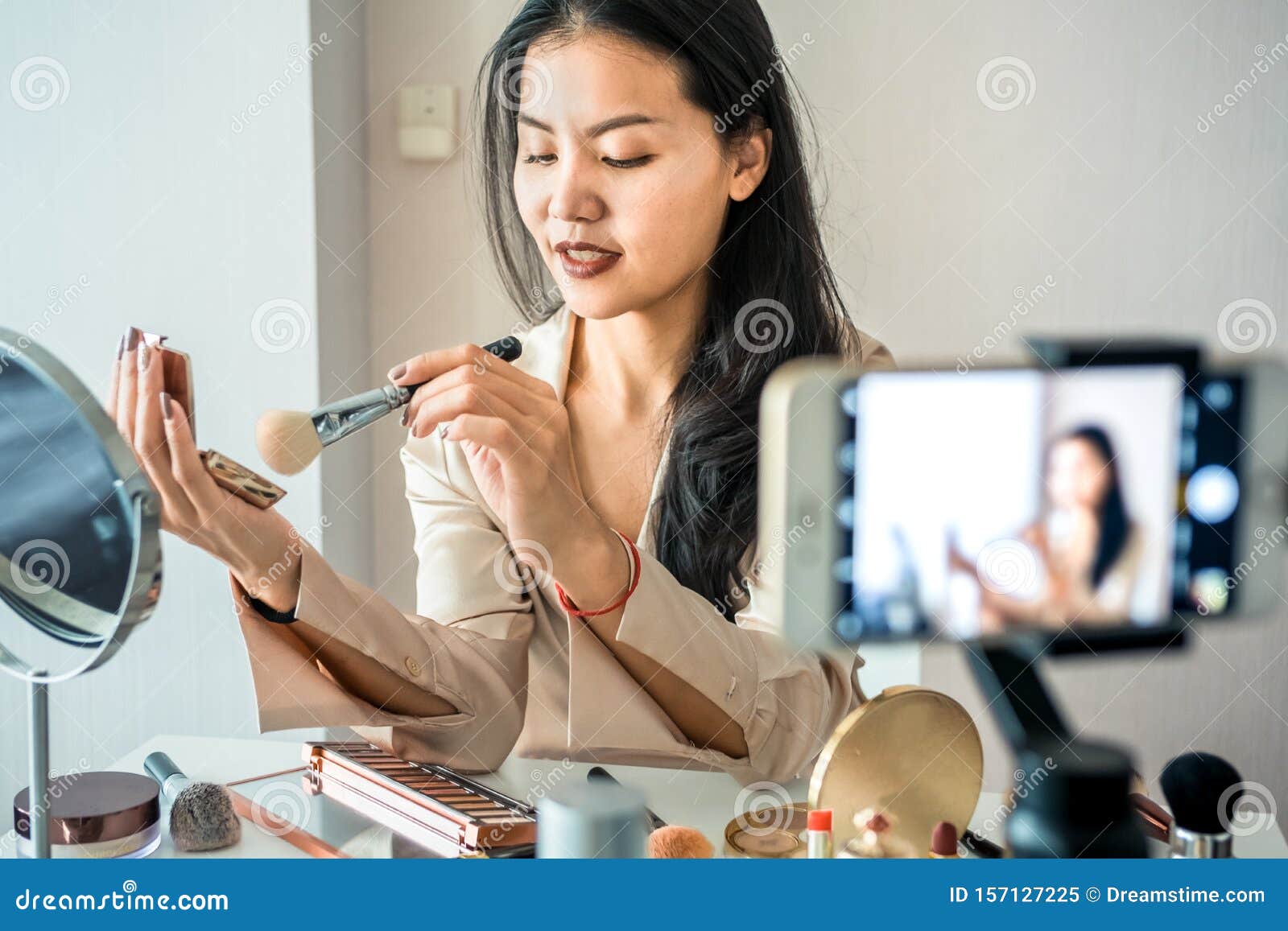 Pretty Woman Using a Smart Phone for Teaching How To Make Up Tutorial ...