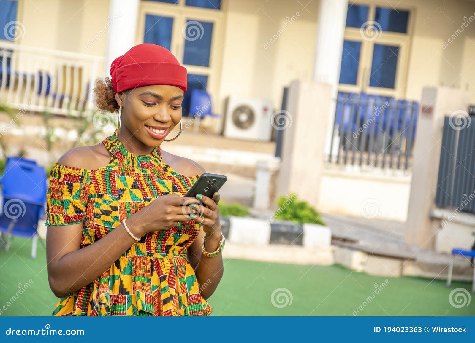 Pretty Young African Woman Smiling and Using Her Mobile Phone Outdoors ...