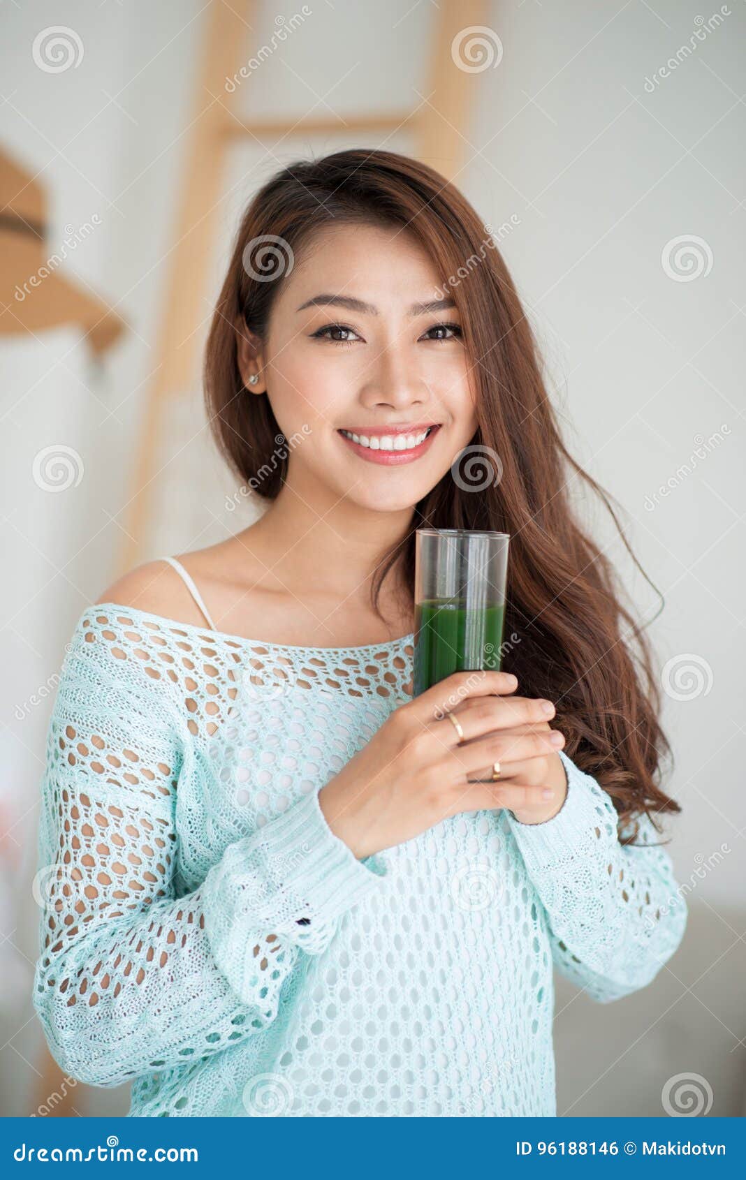 Pretty Young Asian Woman Drinking Green Fresh Vegetable Juice Or Stock