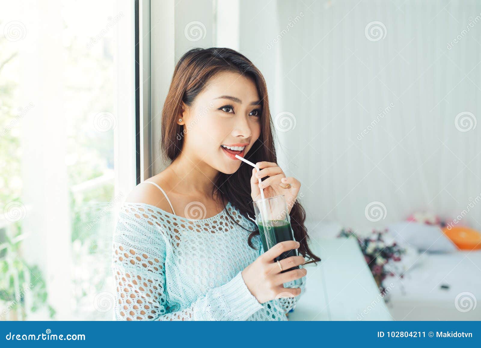 Pretty Young Asian Woman Drinking Green Fresh Vegetable Juice Or Stock