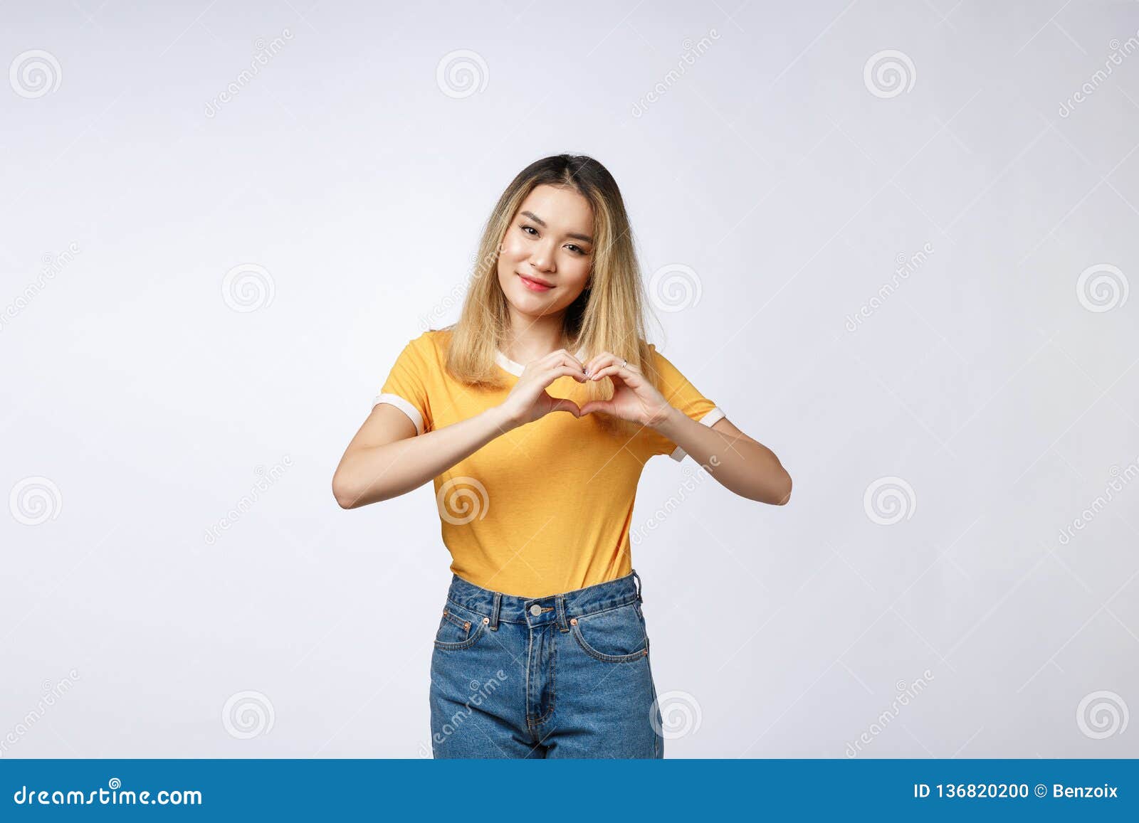 Pretty Young Asian Woman Making A Heart Gesture With Her Fingers In