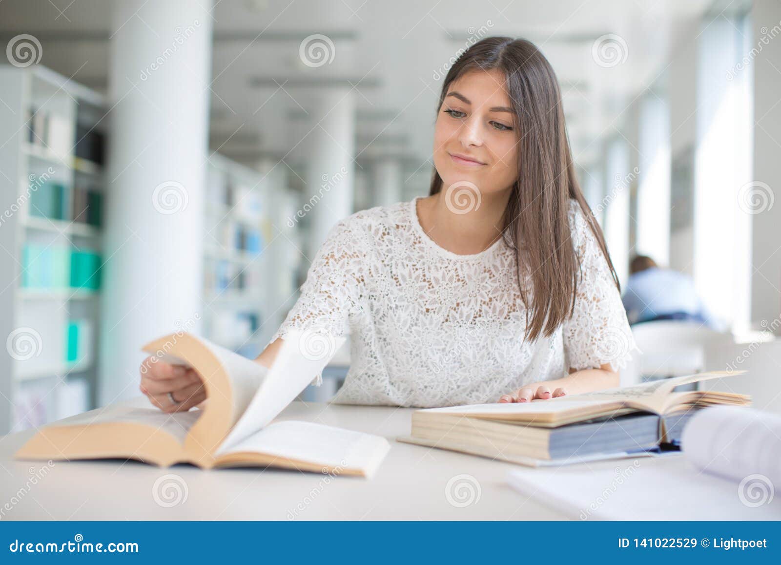 Pretty, Young College Student Looking for a Book in the Library Stock ...