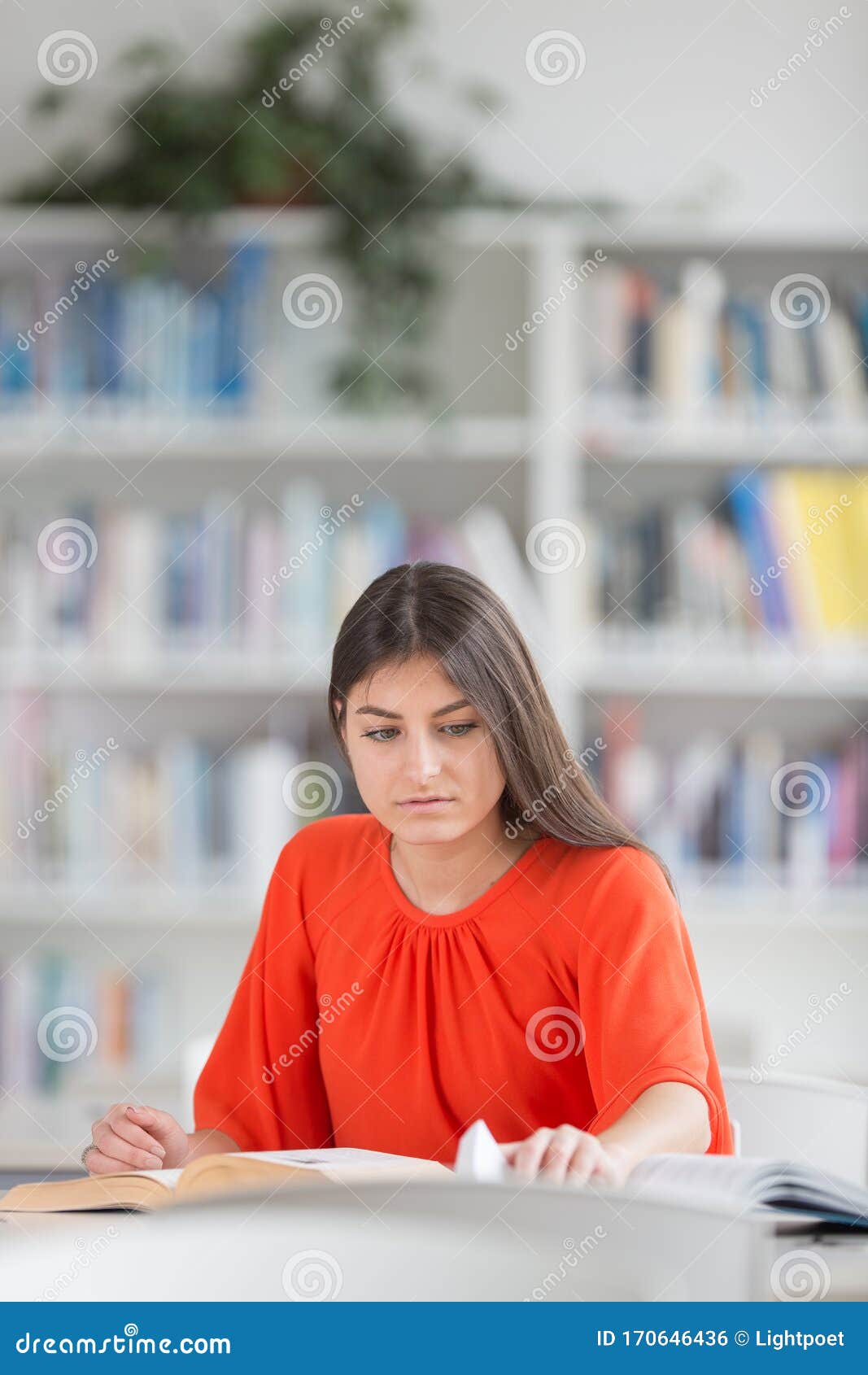 Pretty, Young College Student Looking for a Book in the Library Stock ...