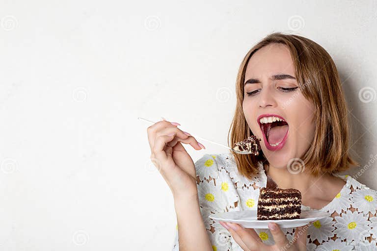 Pretty Young Girl Eating Tasty Chocolate Cake Over White Background