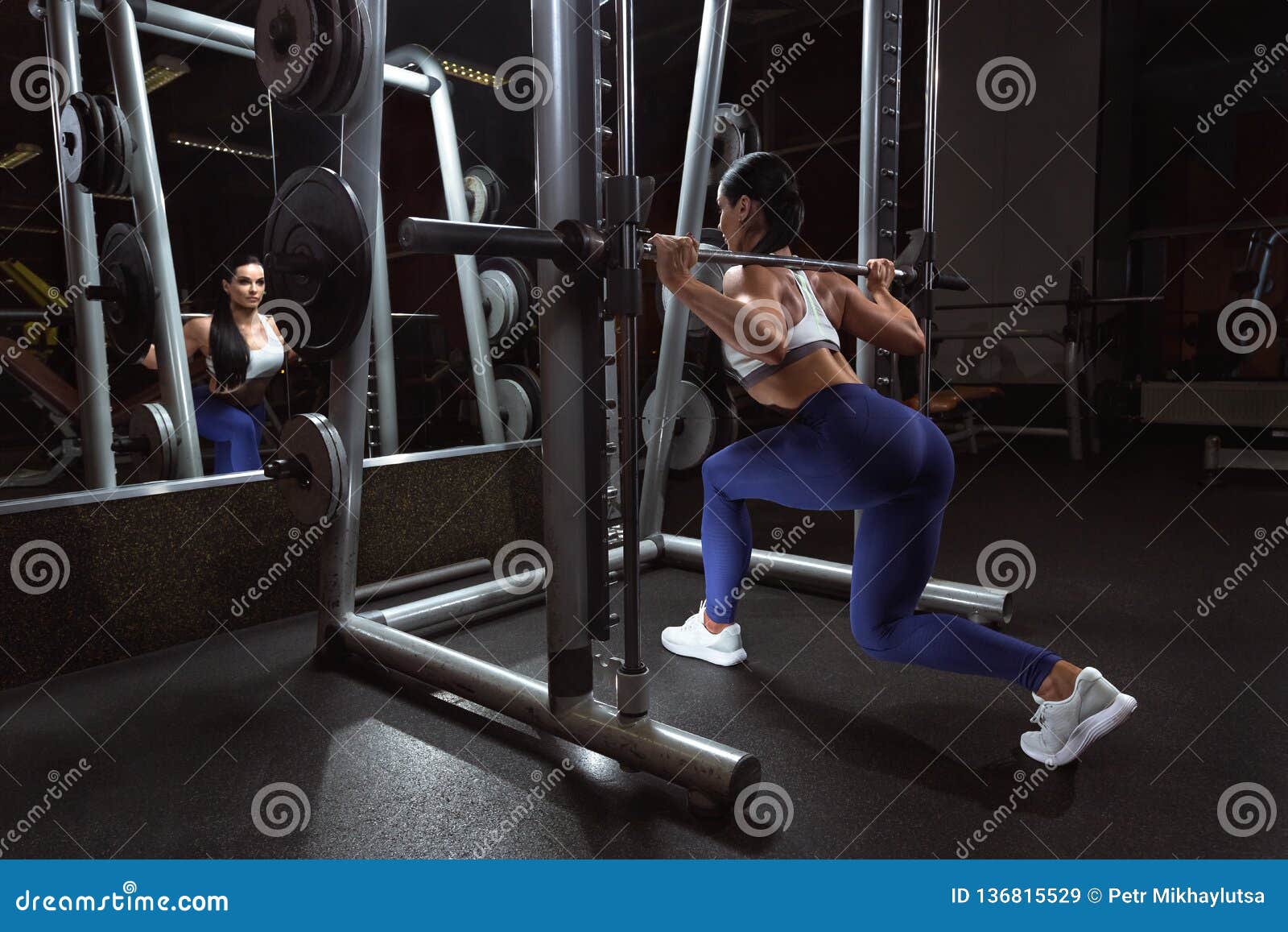 Pretty Young Woman Is Doing Squats With Barbell In The Training
