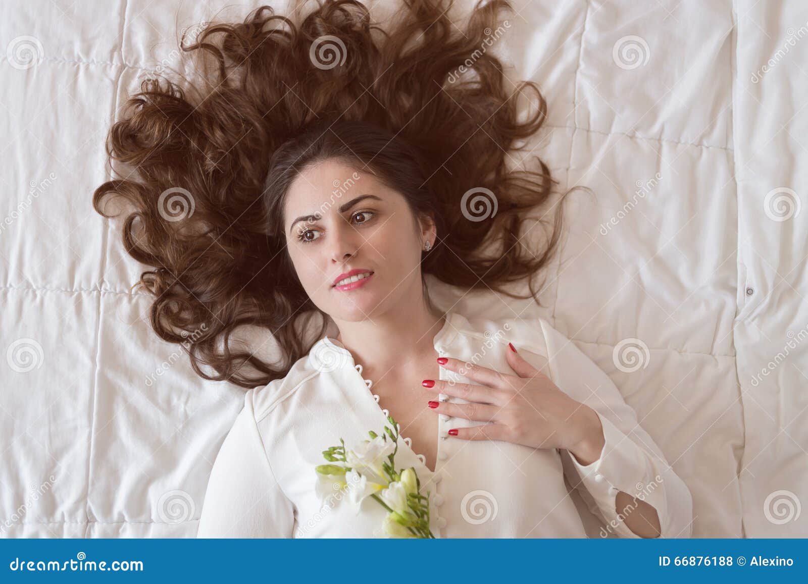 Pretty Young Woman With Beautiful Long Hair Lying On The Bed Stock