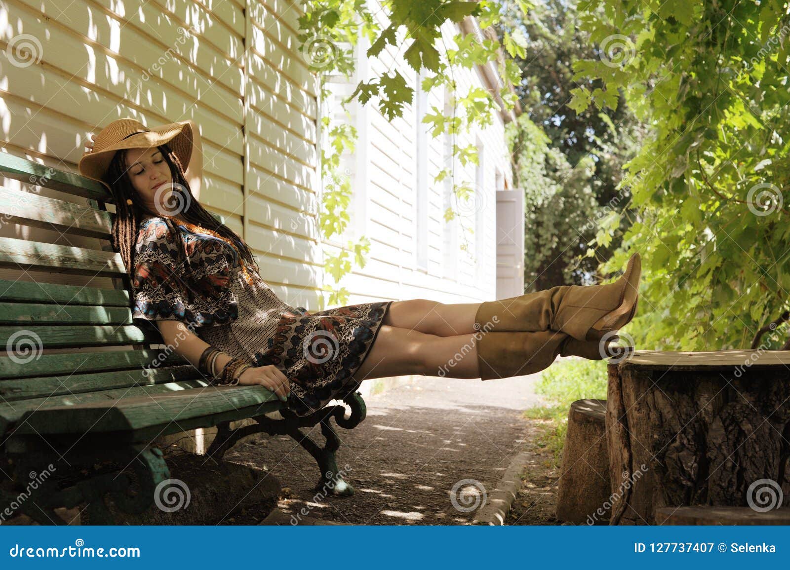 Pretty Young Woman With Dreadlocks Dressed Resting Outdoor Near Her