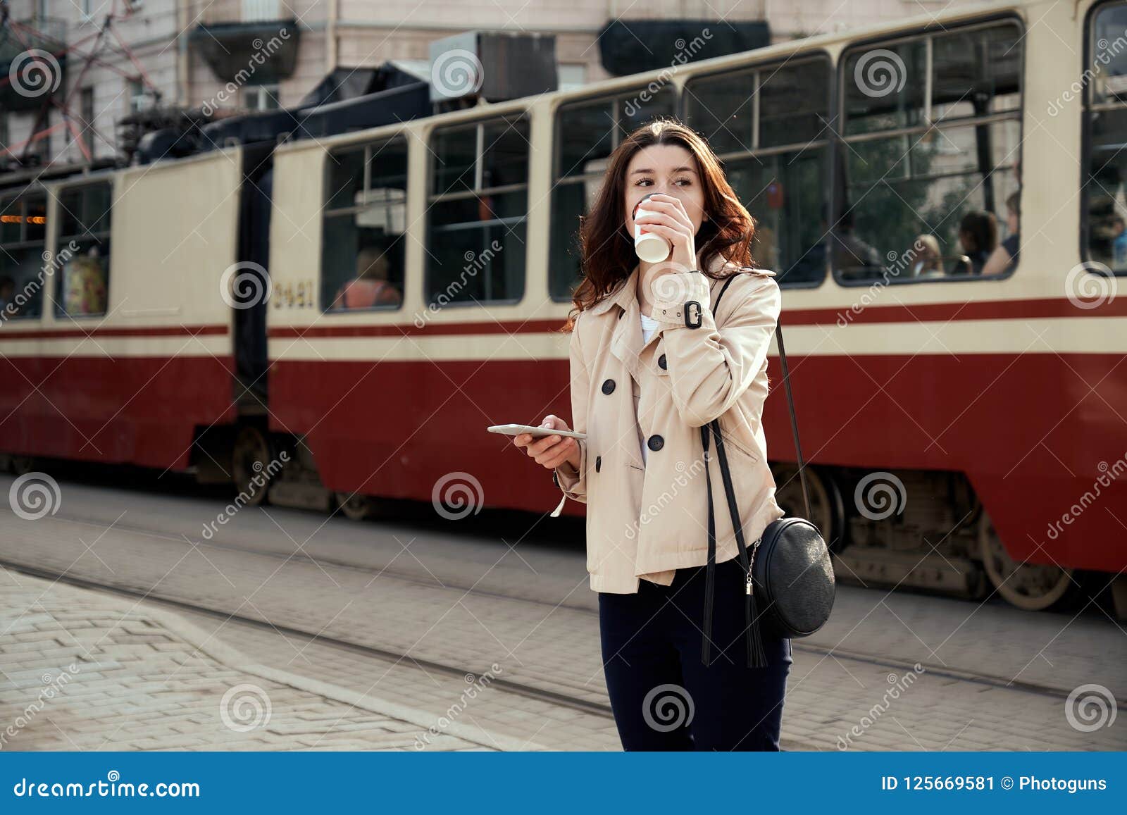 Pretty Young Woman Drinking Takeout Coffee Cup, Using Smart Phone while ...