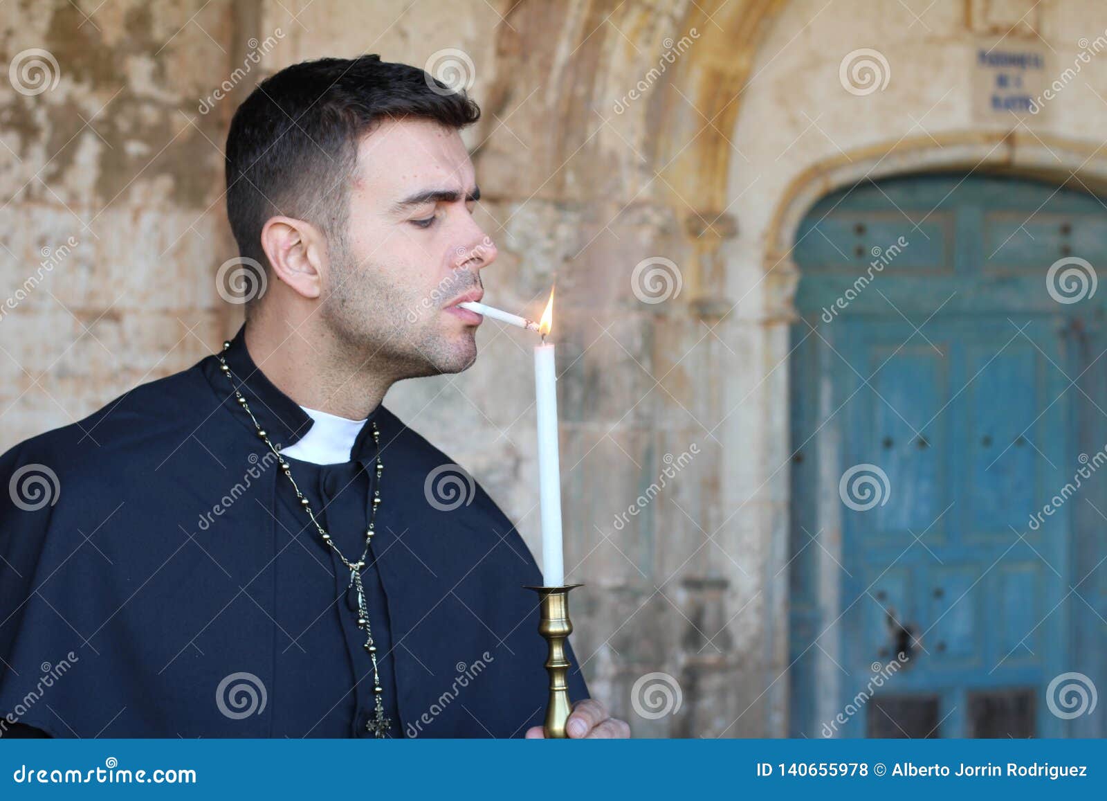 Priest Lighting a Cigarette with a Candle Stock Photo - Image of ...