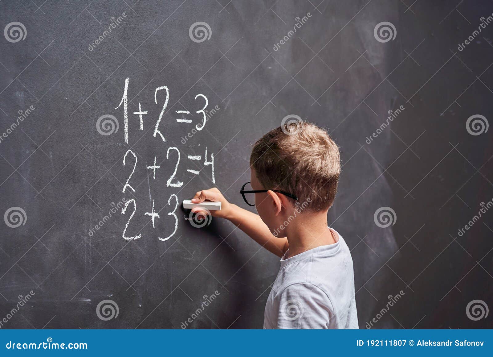 Primary Education. Side View a Student Solves a Math Example on a ...