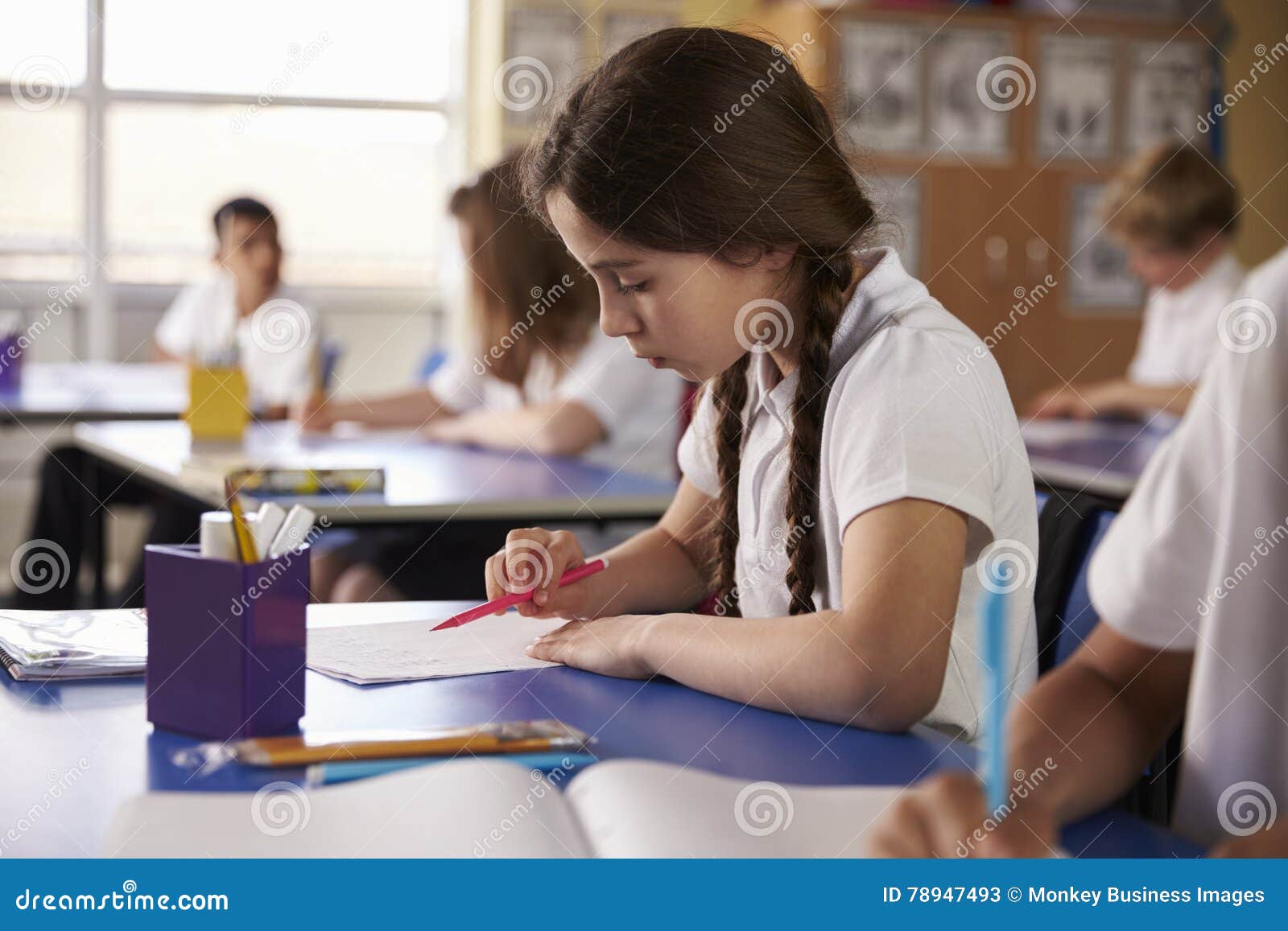 Primary School Girl Working at Her Desk in Class Stock Image - Image of ...