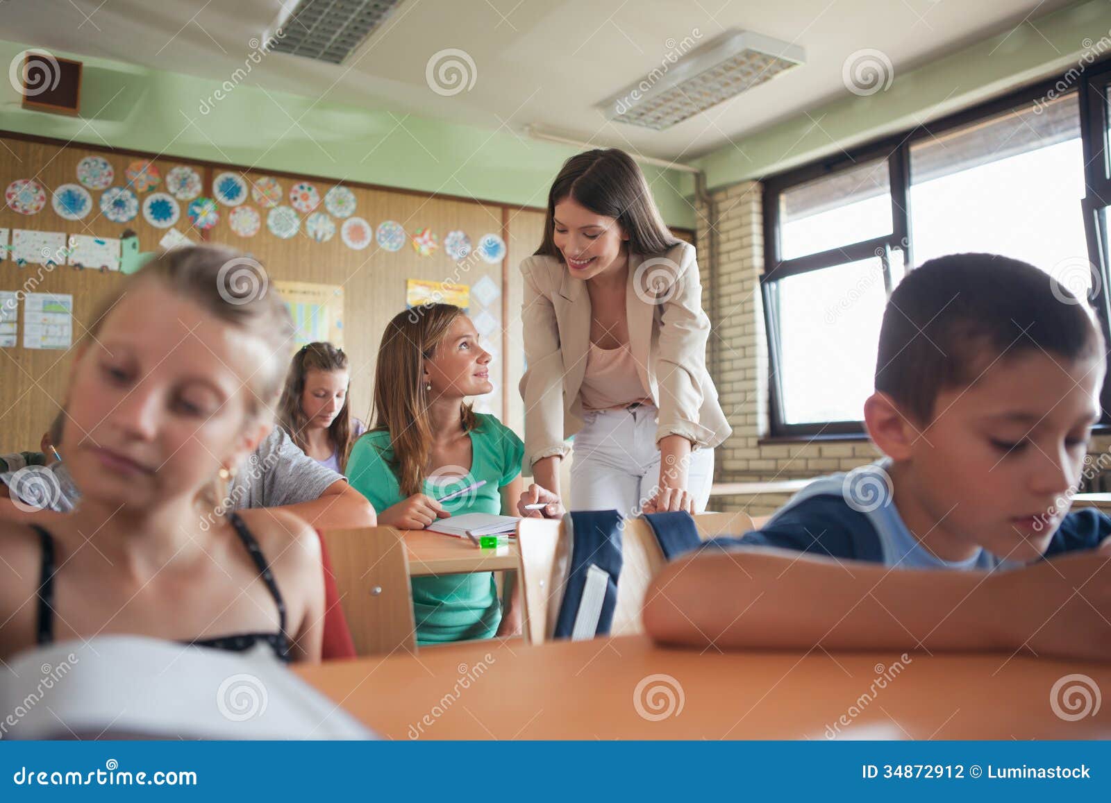 Primary School Teacher Helping Students Stock Photo - Image of happy ...