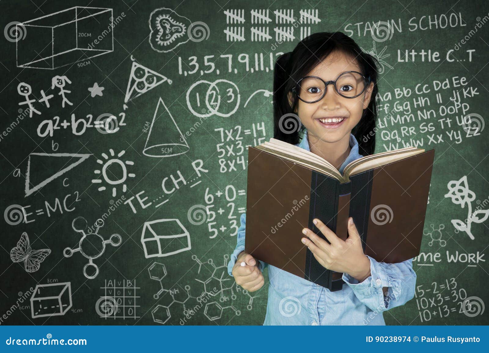 Primary Student Holding Book in Classroom Stock Photo - Image of ...