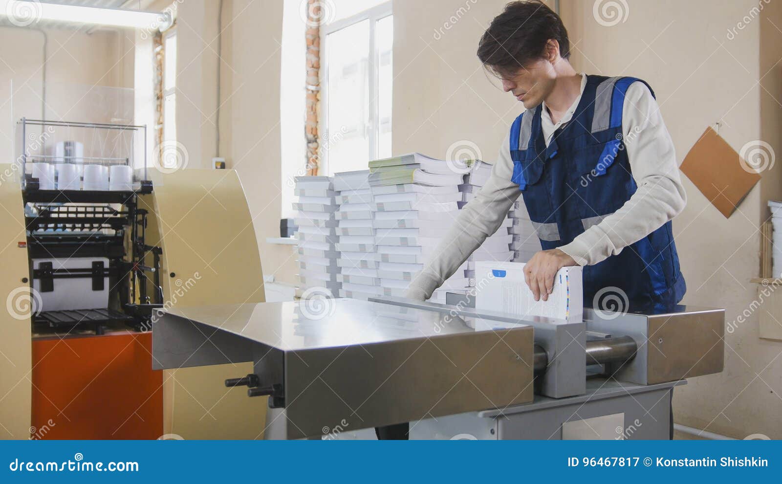 Printing Process - Worker Inserts Paper Sheets in Industrial Press ...