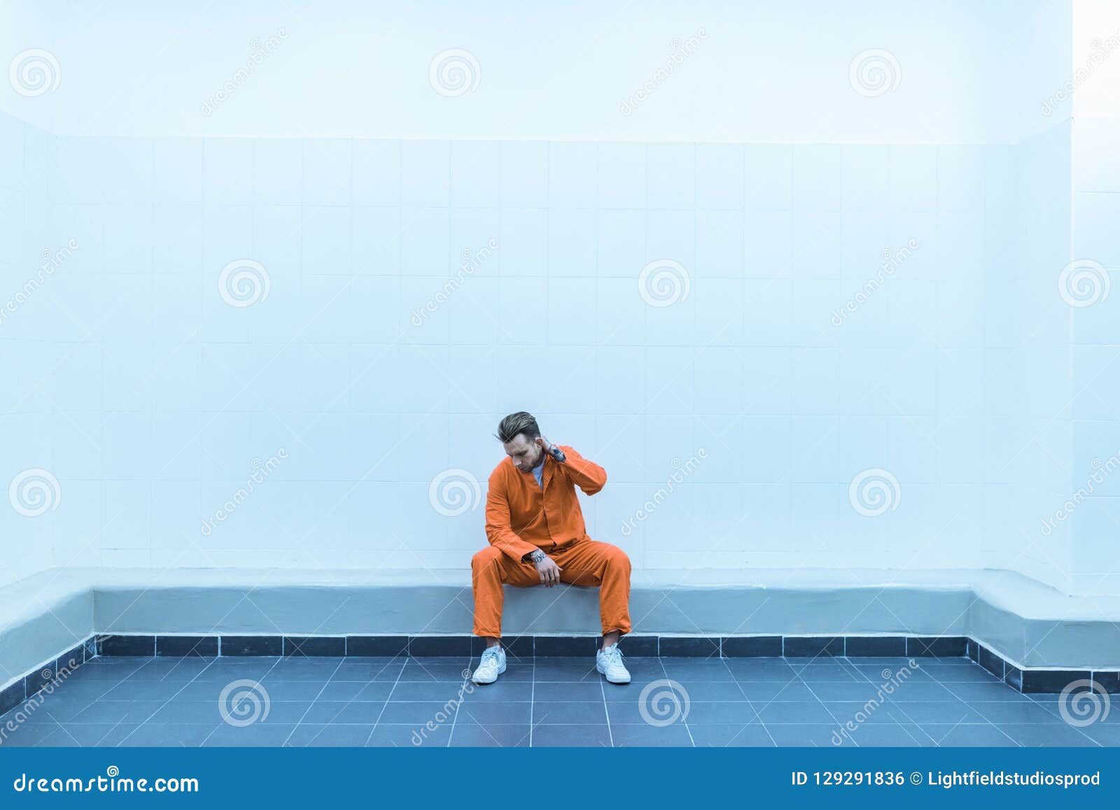 Prisoner sitting on bench stock photo. Image of prison - 129291836