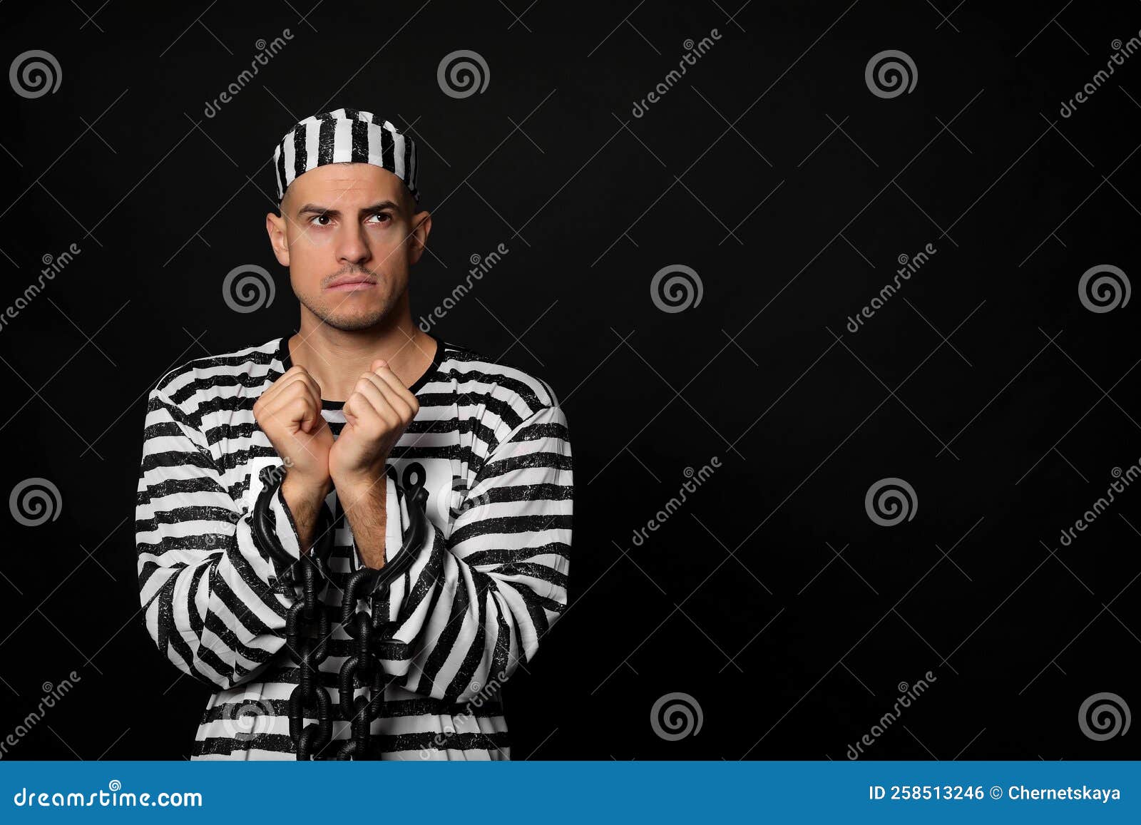 Prisoner in Striped Uniform with Chained Hands on Black Background ...