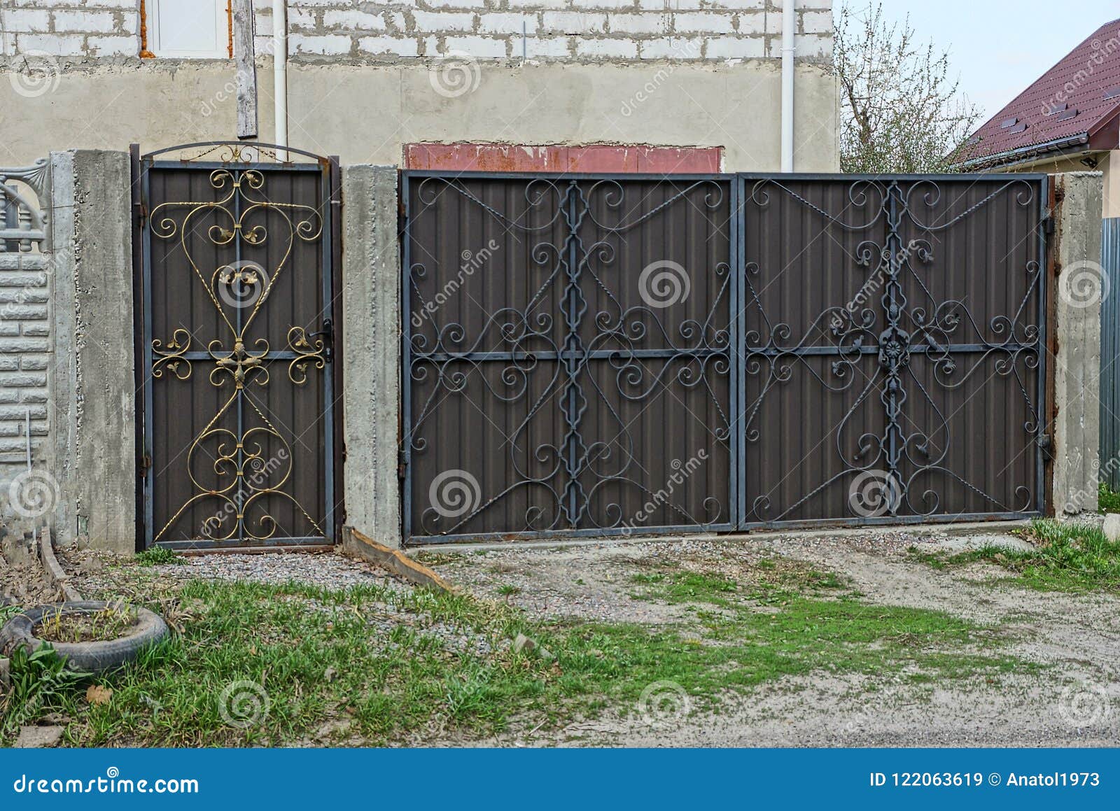 A Brown Metal Gate and a Large Gate with a Black Forged Pattern on the ...