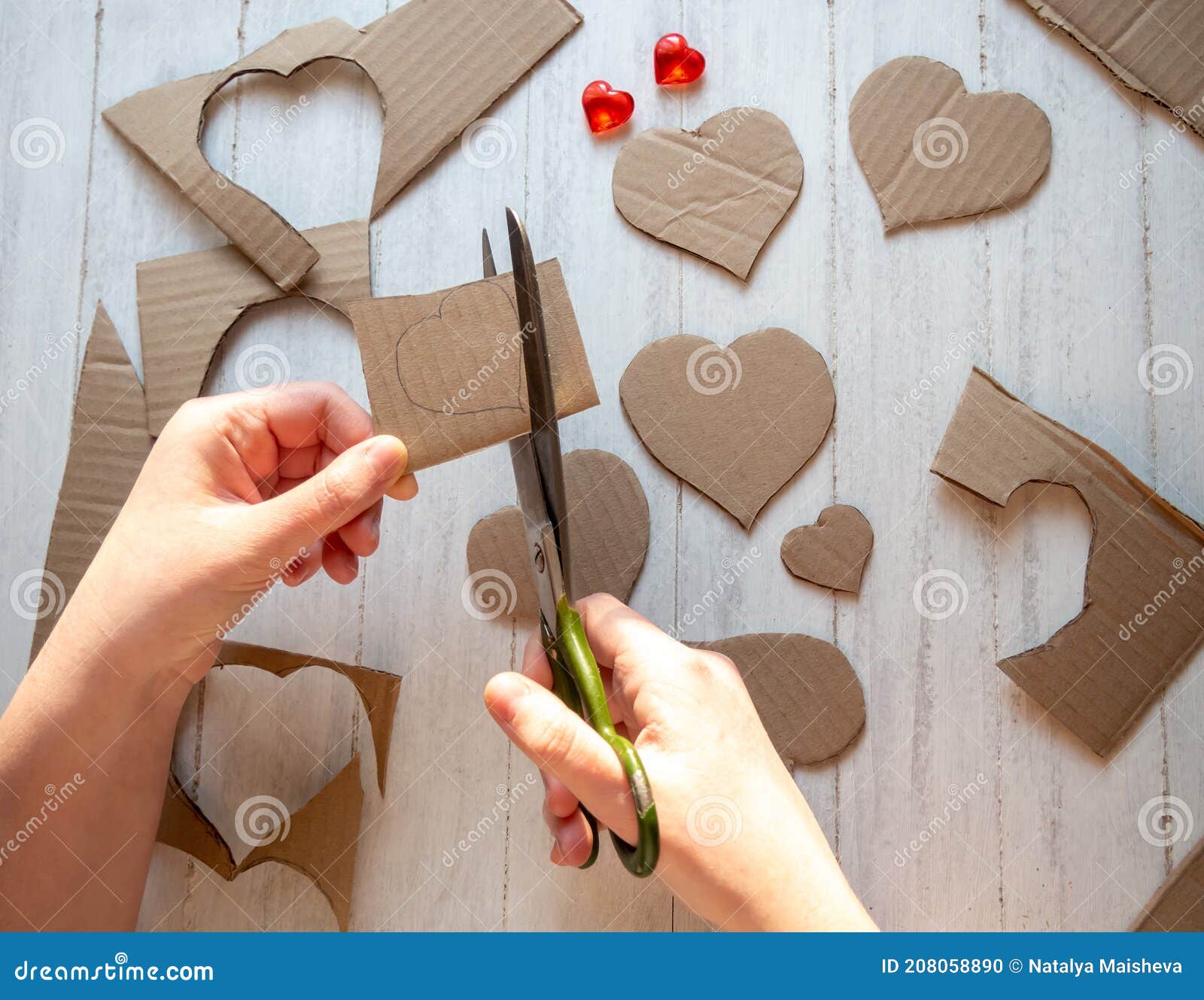 The Process of Cutting Out Hearts with Scissors from Cardboard. the ...