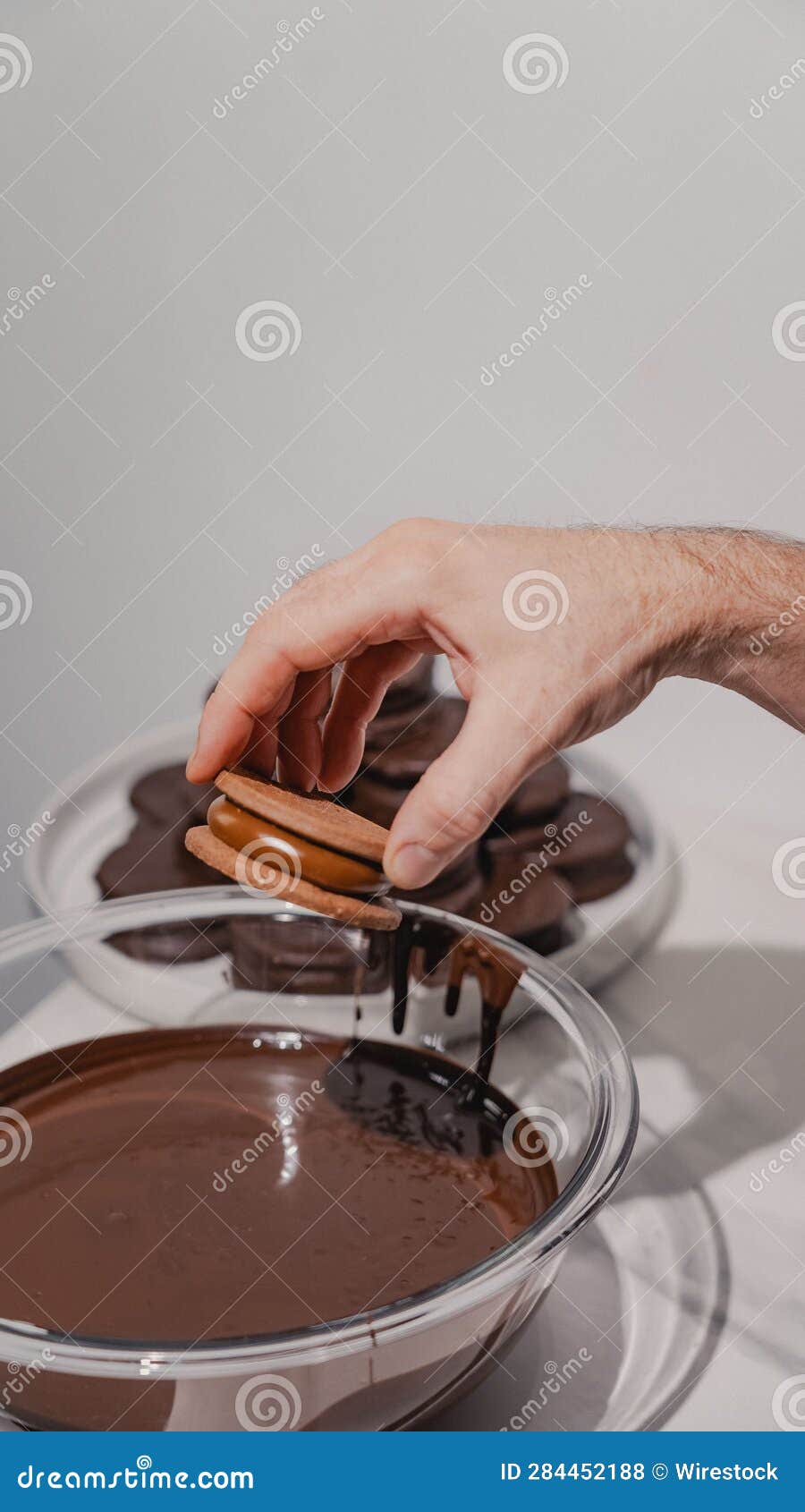 Process of Dipping a Cookie into a Bowl of Melted Chocolate Stock Photo ...
