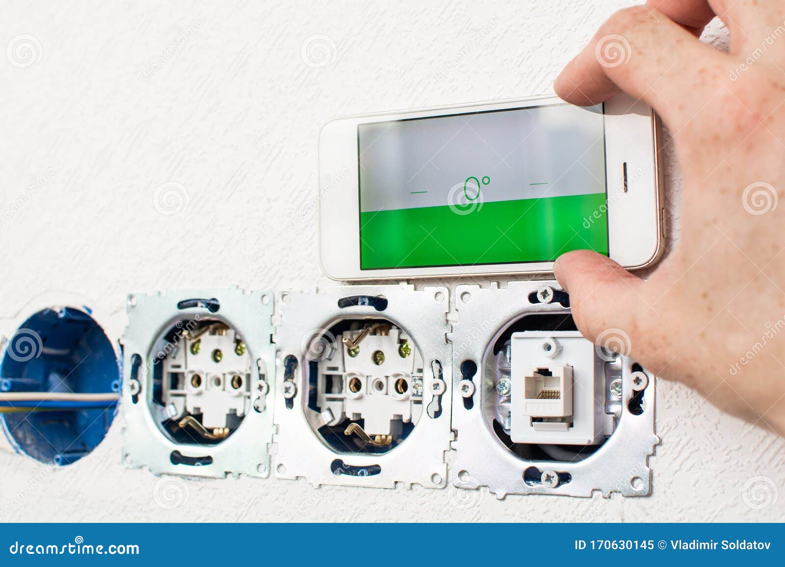 The Process of Installation Electrical Sockets Level with a Smartphone ...