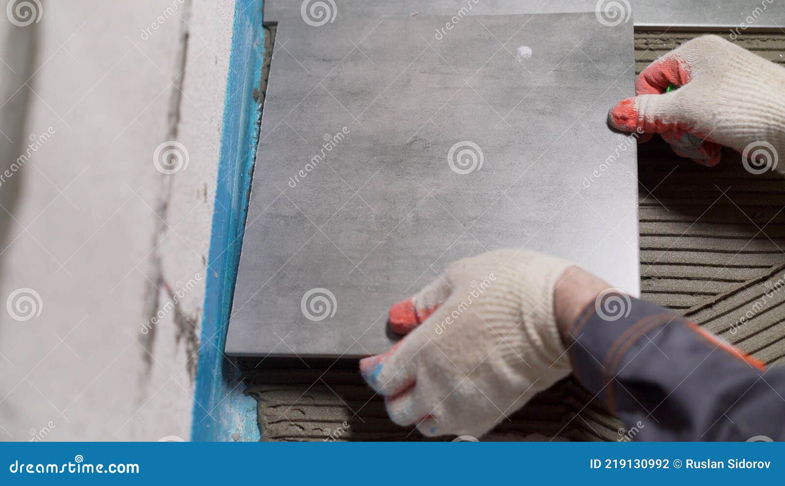 Process Of Laying Ceramic Tiles On Floor Smeared With Glue. Workers ...