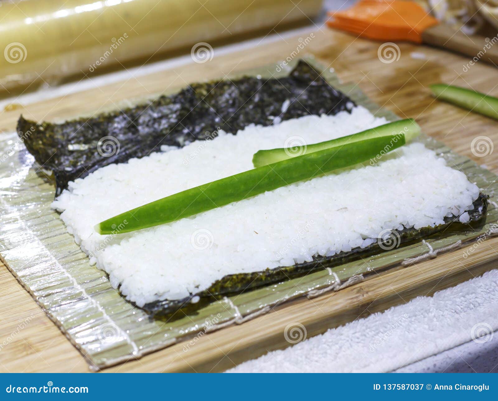 The Process of Making Sushi and Rolls with Cucumber. Rice on Nori Sheet ...