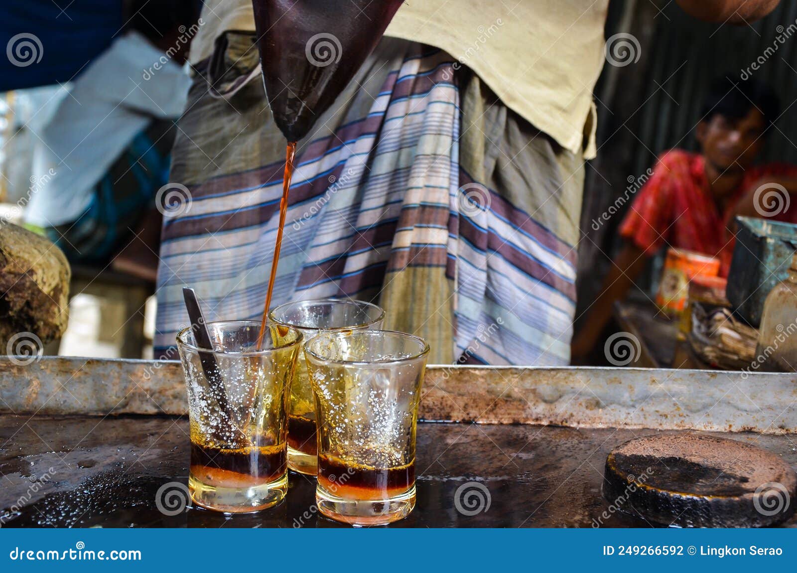 The Process of Making Tea in a Tea Stall. the Dark Liquid Tea Falling ...