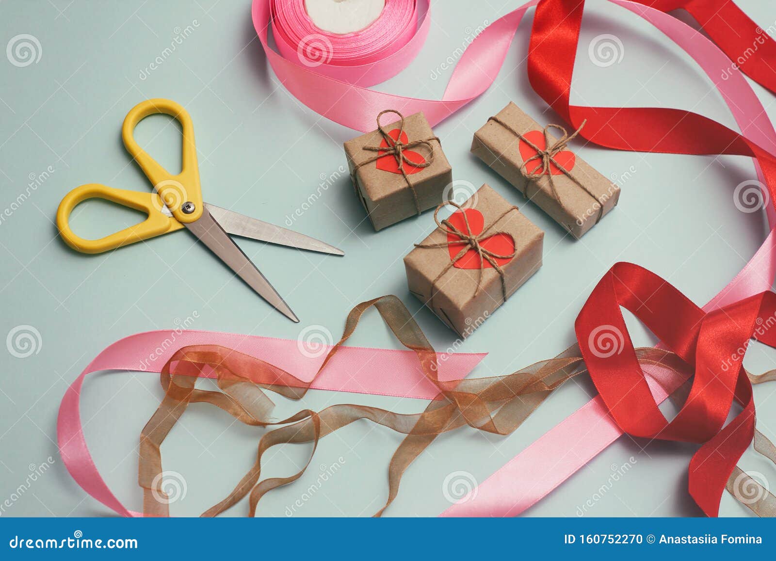 Process of Packing Presents in Gift Boxes. Craft Paper, Scissors, Hemp ...